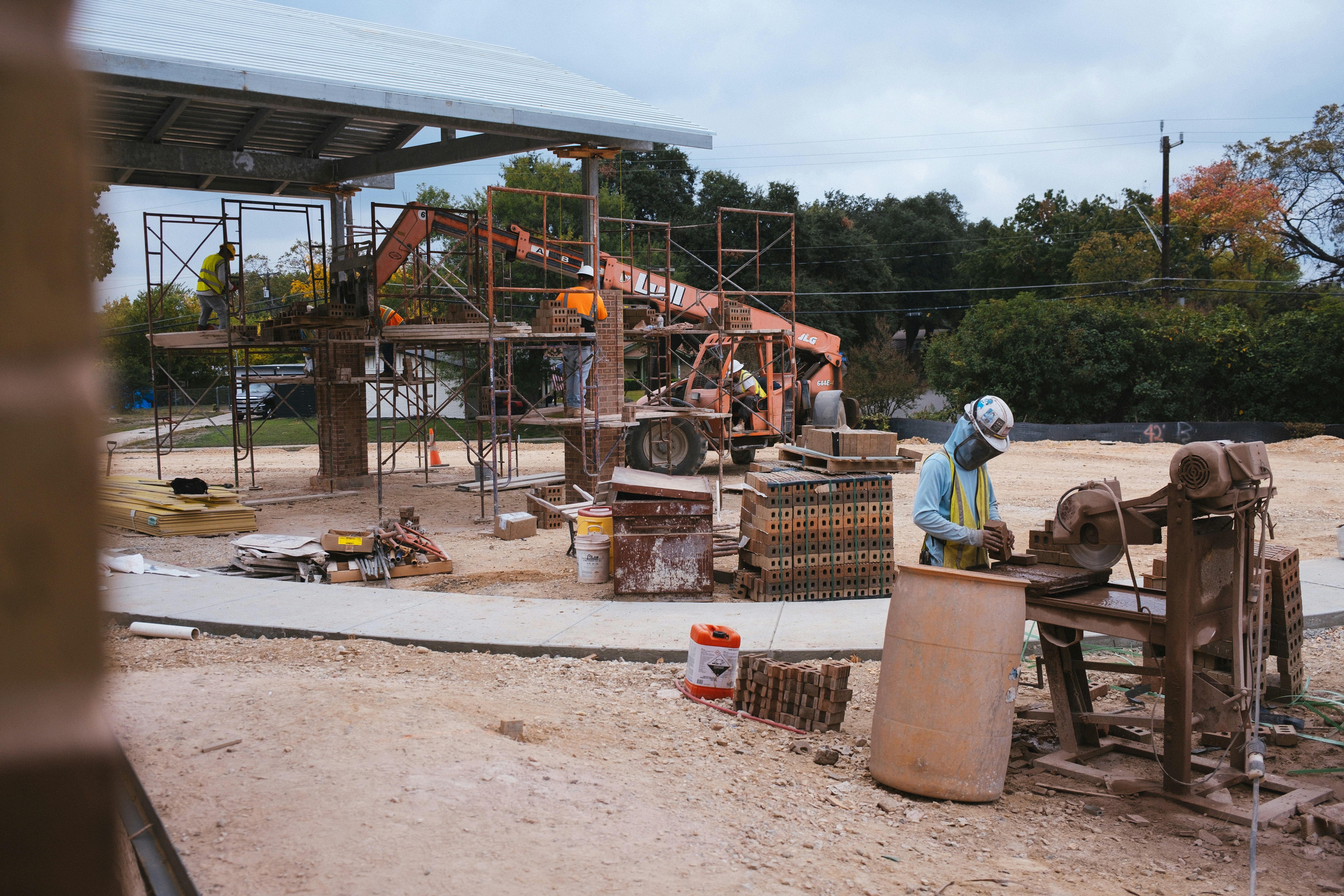 Construction Hands at Work: A Copper-toned Site Under a Steel Canopy