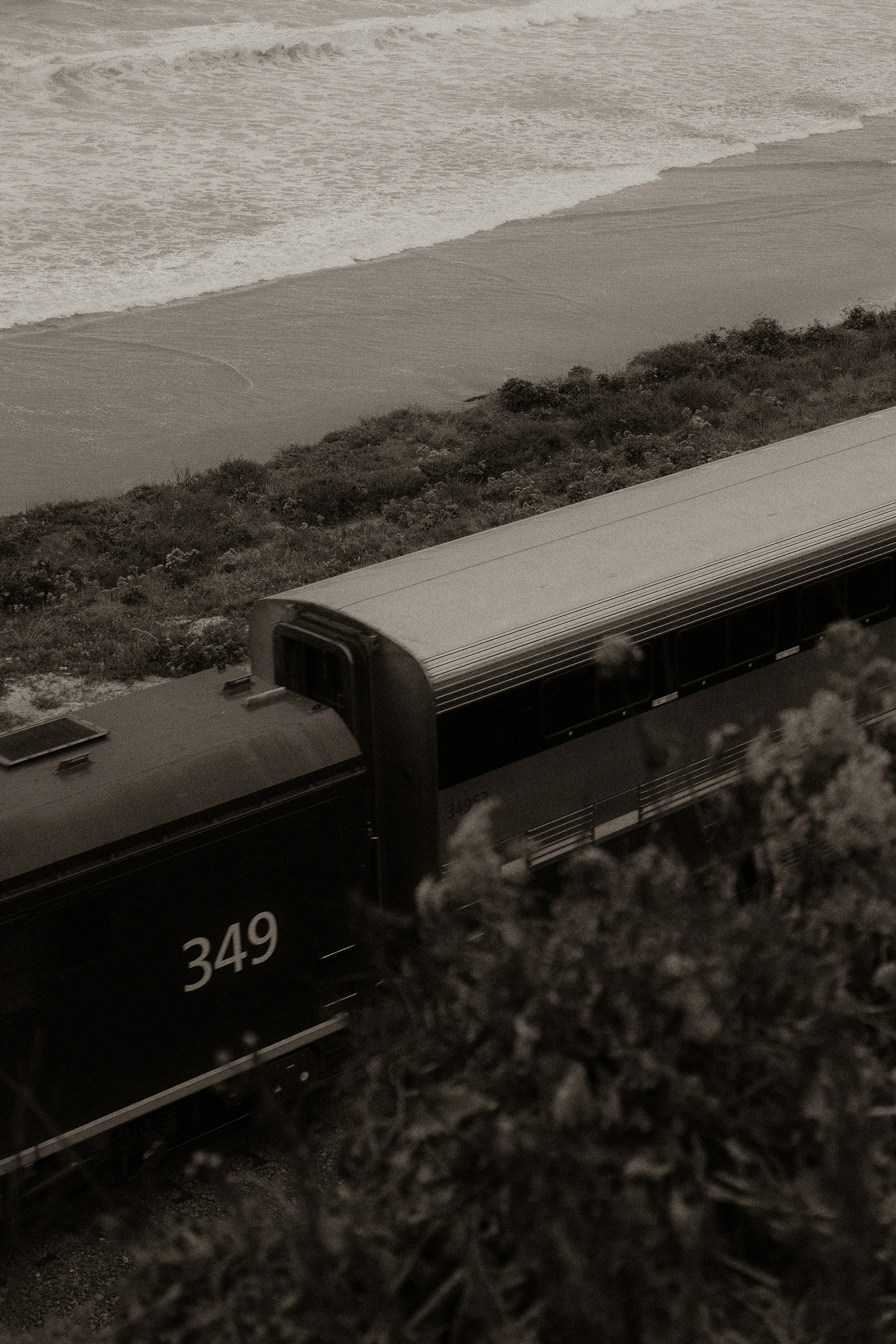 Muted Rails, Quiet Shoreline: A Sepia Moment of a Train by the Sea