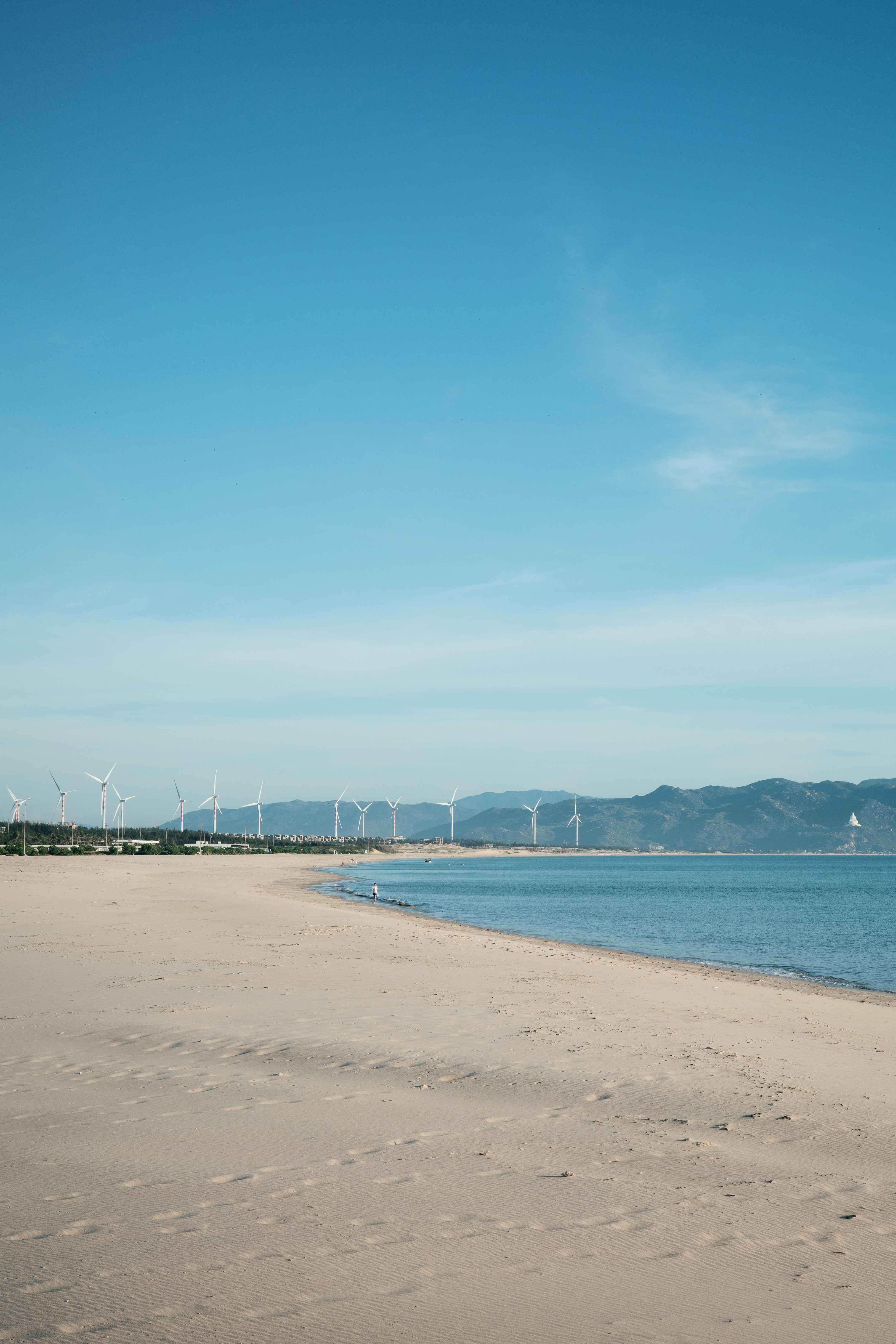 Coastal Horizon with Wind Turbines on a Quiet Beach