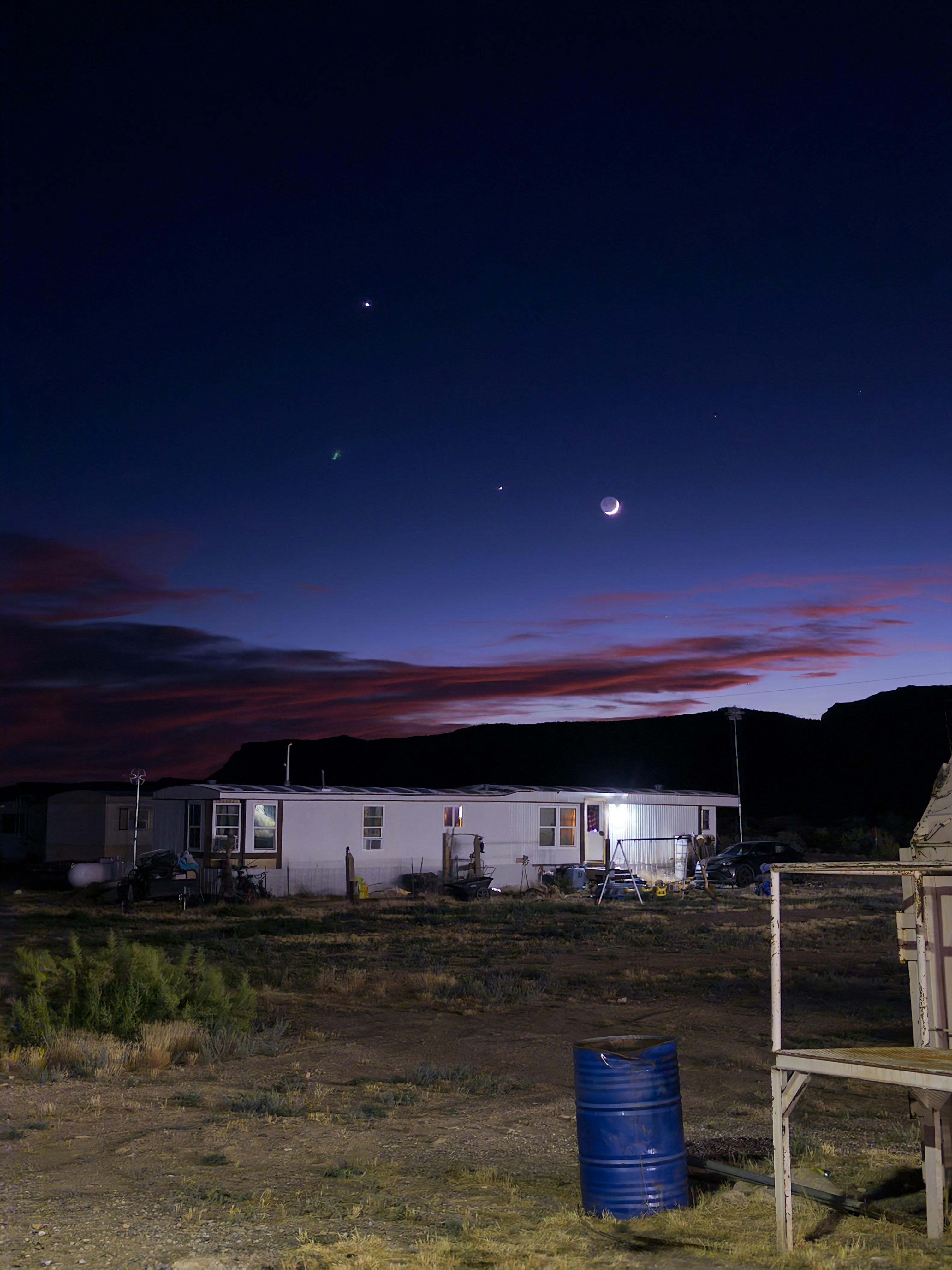 A house under a twilight sky with moon and stars.