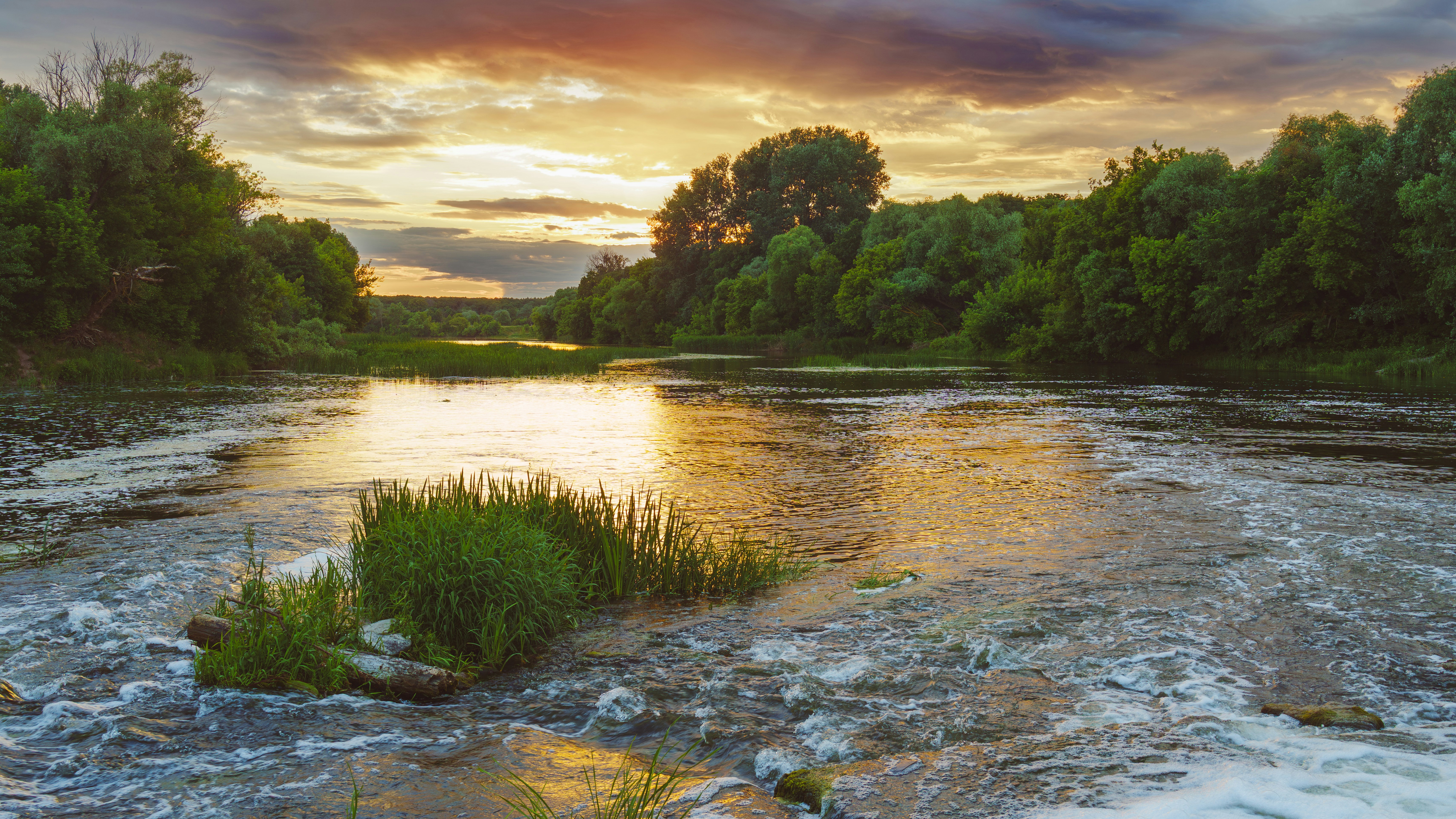 Golden River at Dusk: Reeds, Water and a Looming Sky