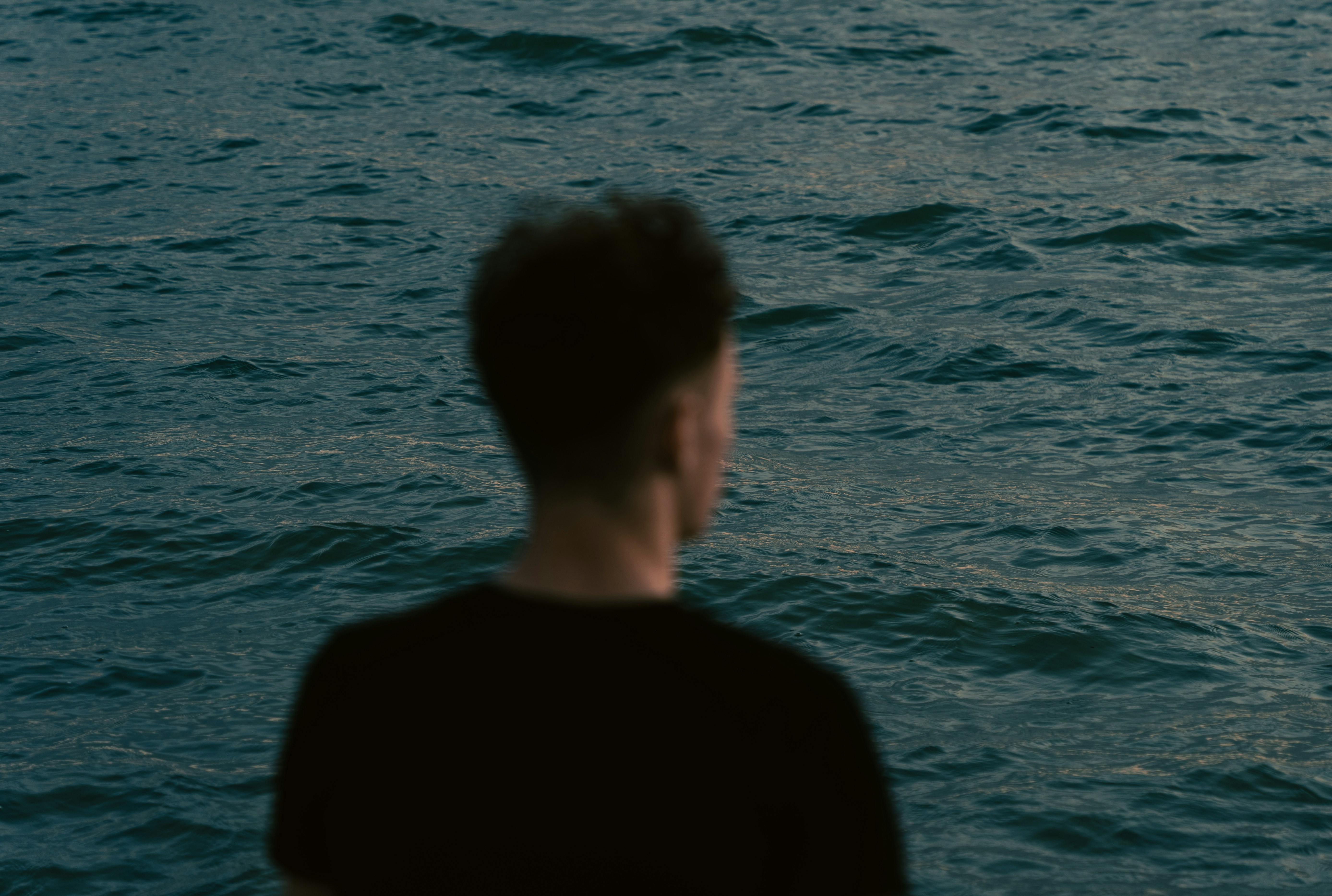 Silhouette at the Edge: A Figure Gazes Toward the Sea