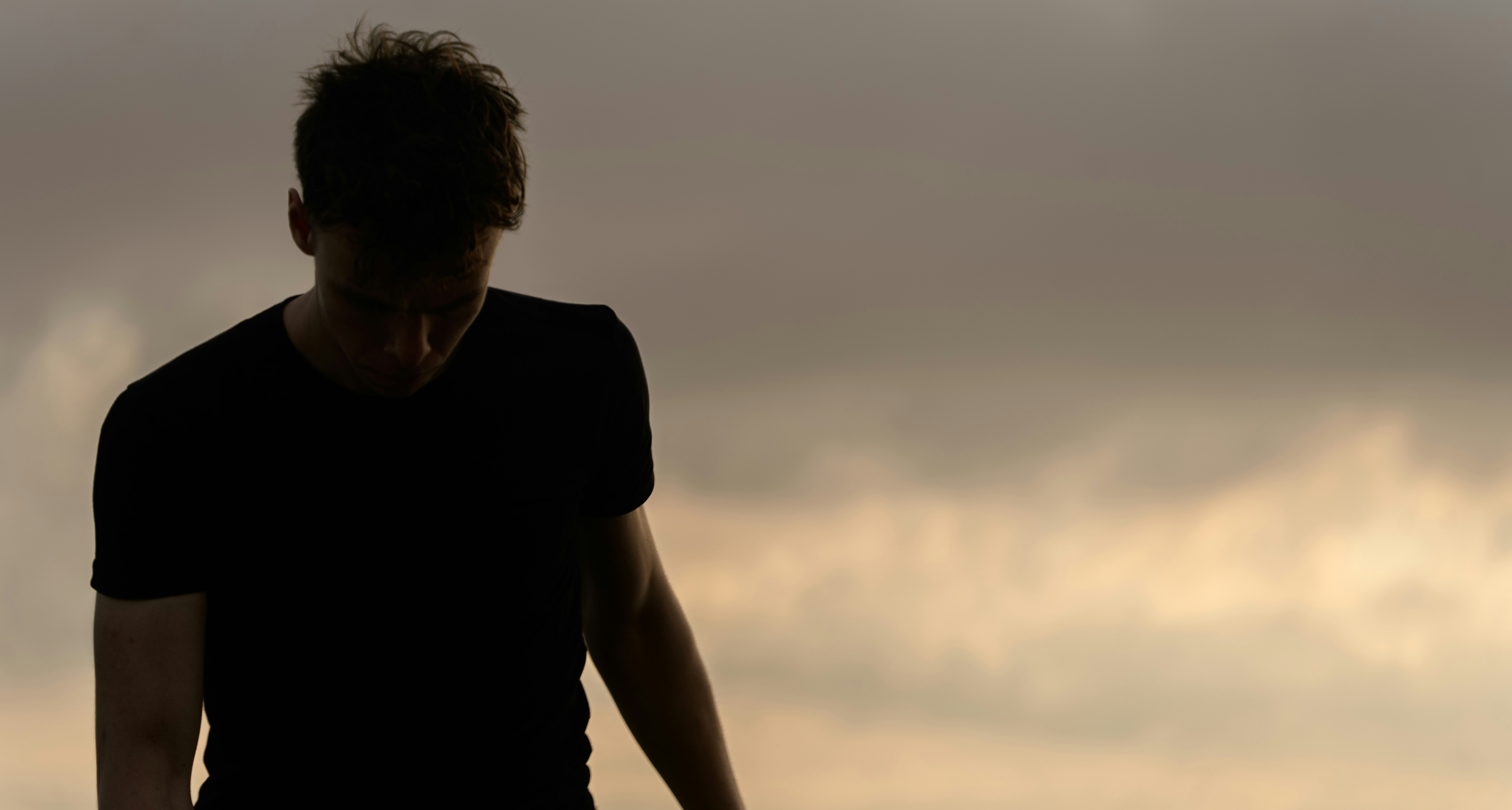 Silhouette at Dusk: A Quiet Portrait Against a Clouded Sky