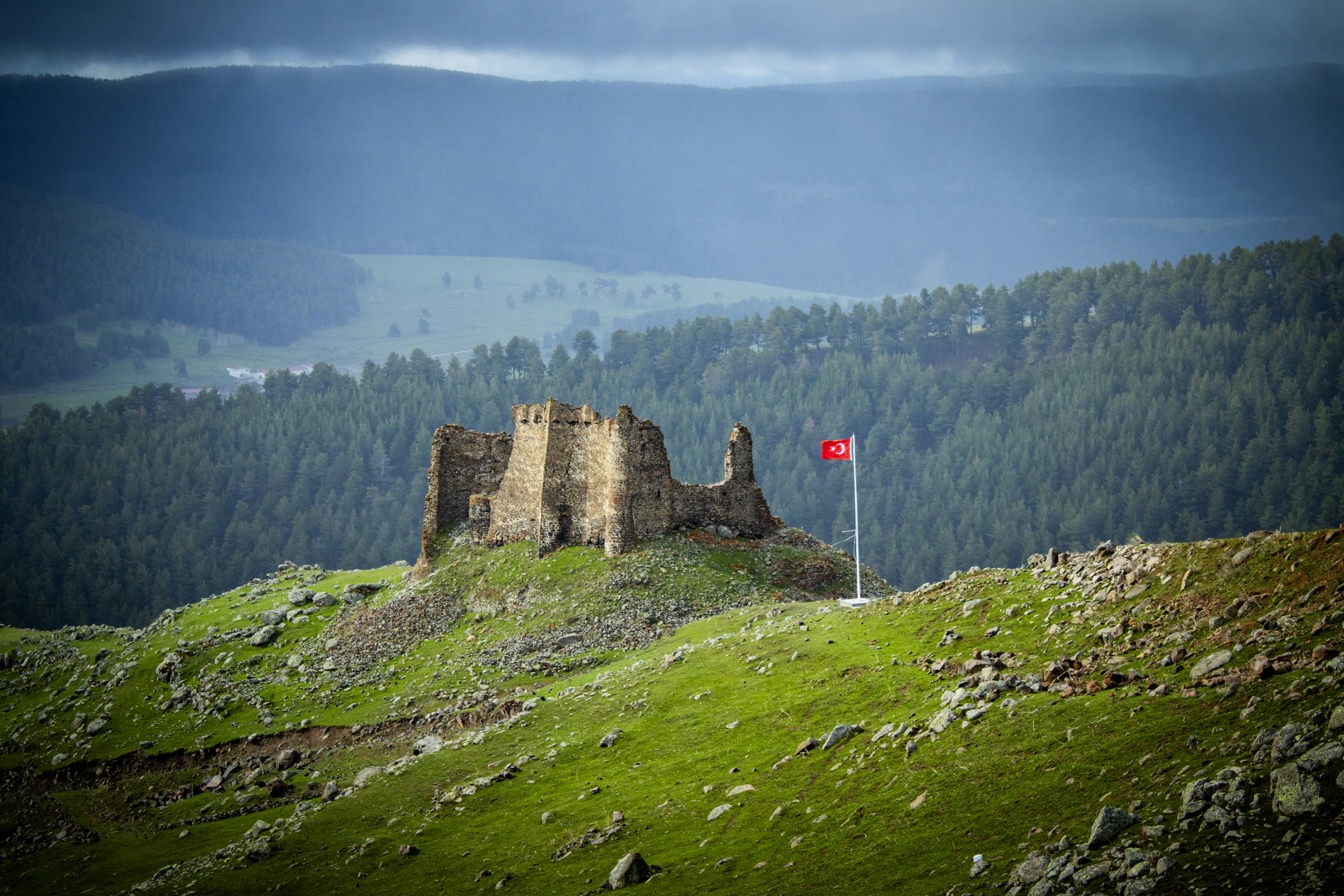 Turkish Ruins on Green Hills Beneath a Misty Ridge