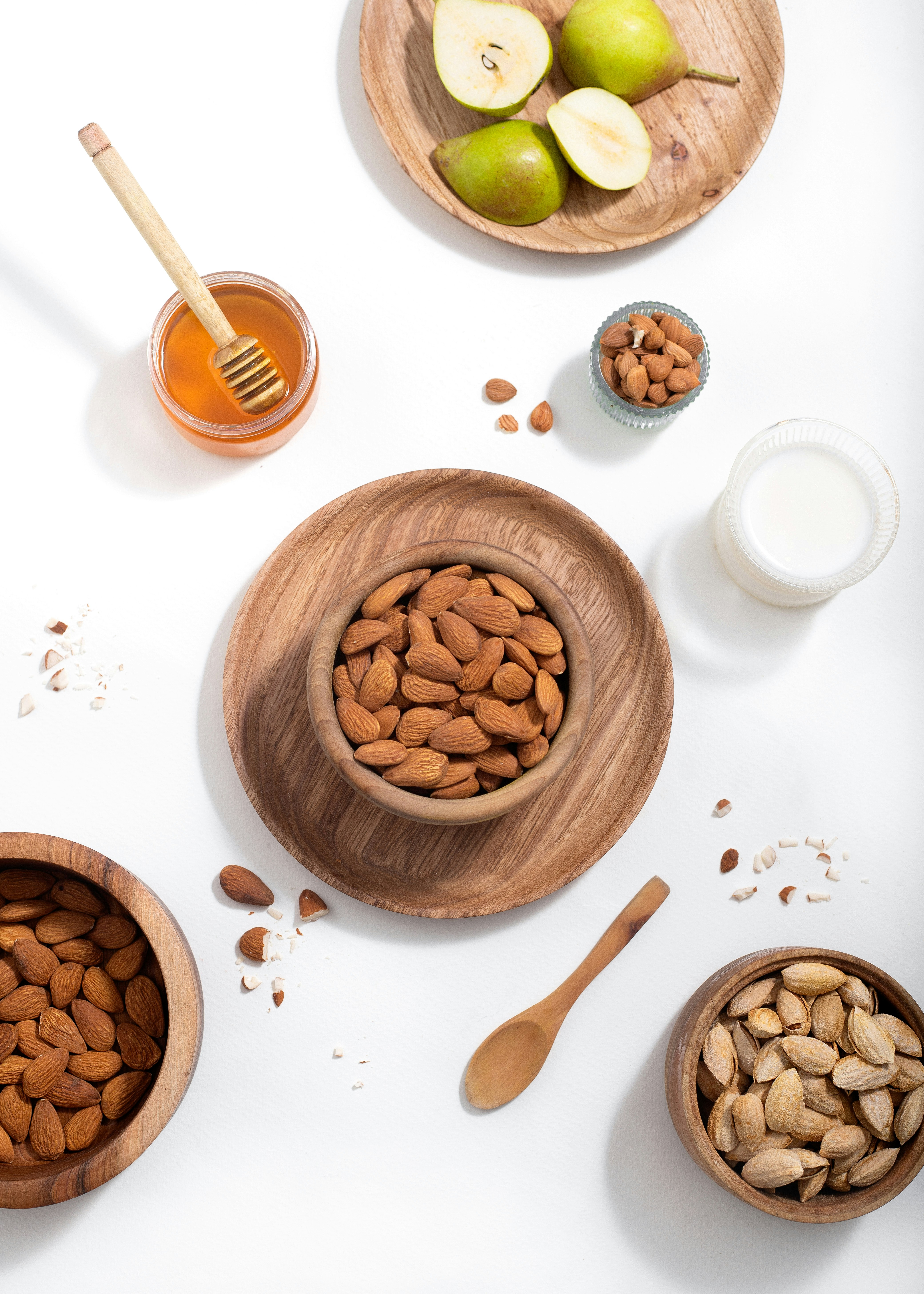 Almonds and accompaniments arranged on a white studio surface
