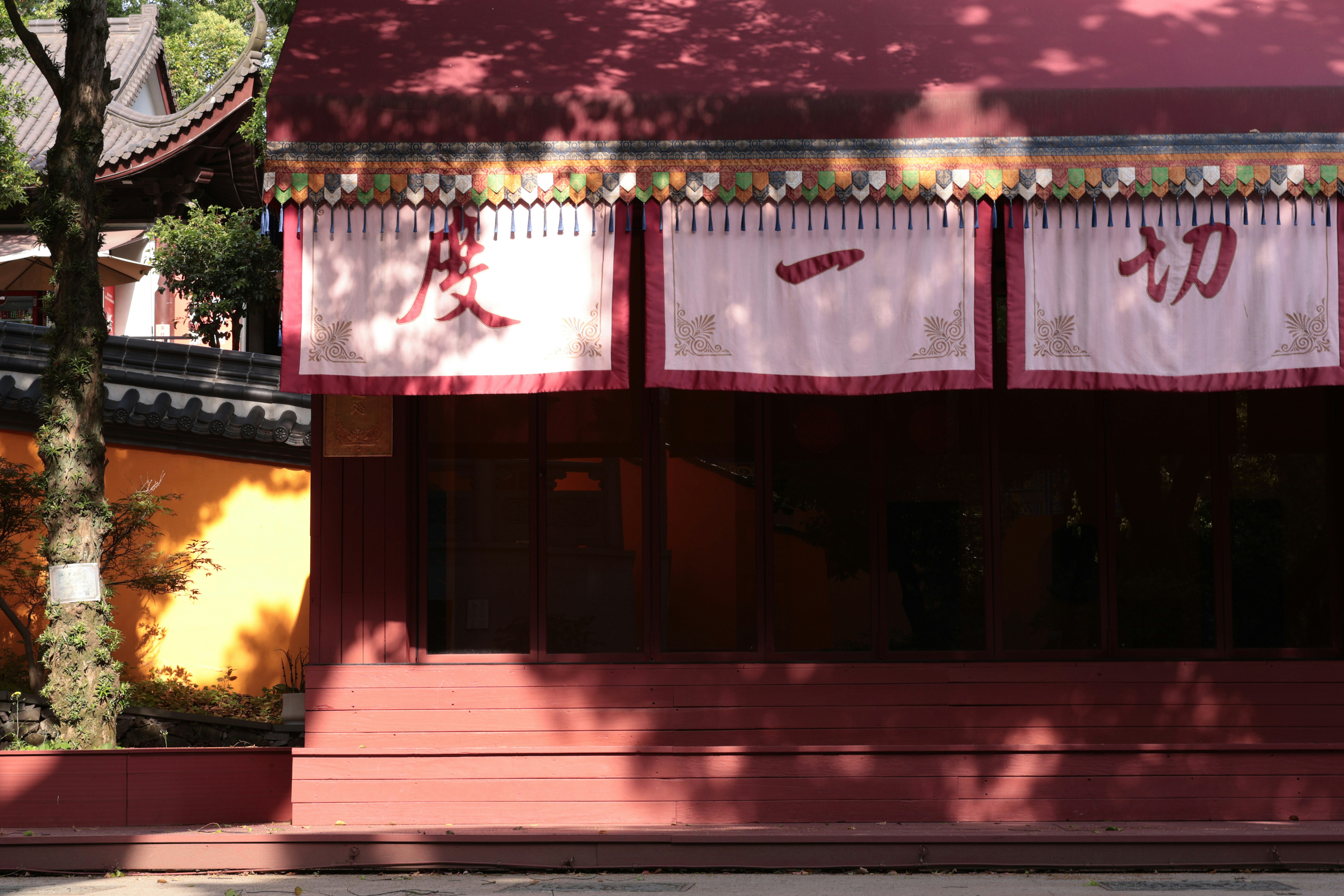 Red-Toned Temple Facade with Hanging Scrolls and Shadow Play