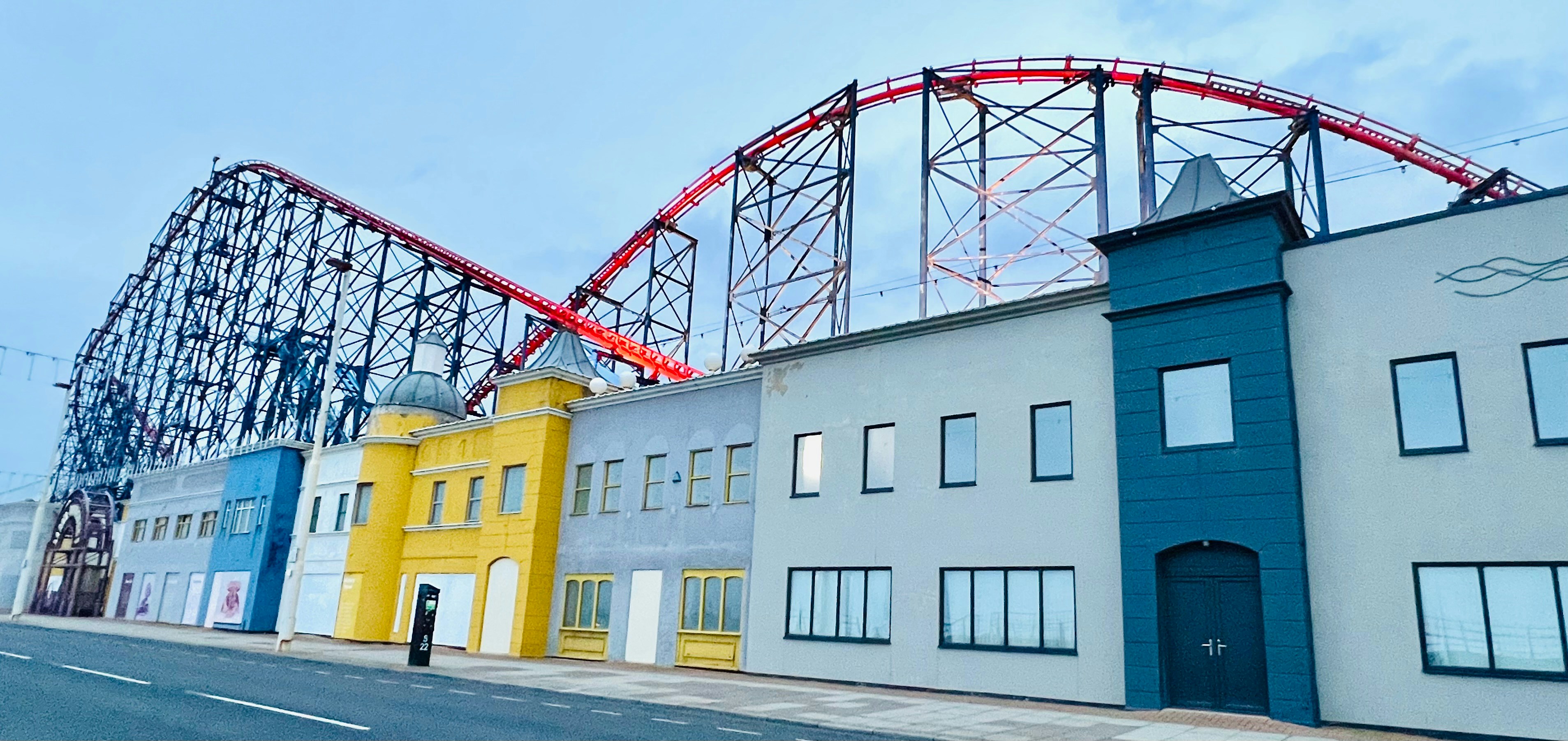 Colorful Row of Industrial Buildings with Red Roller Coaster Rails