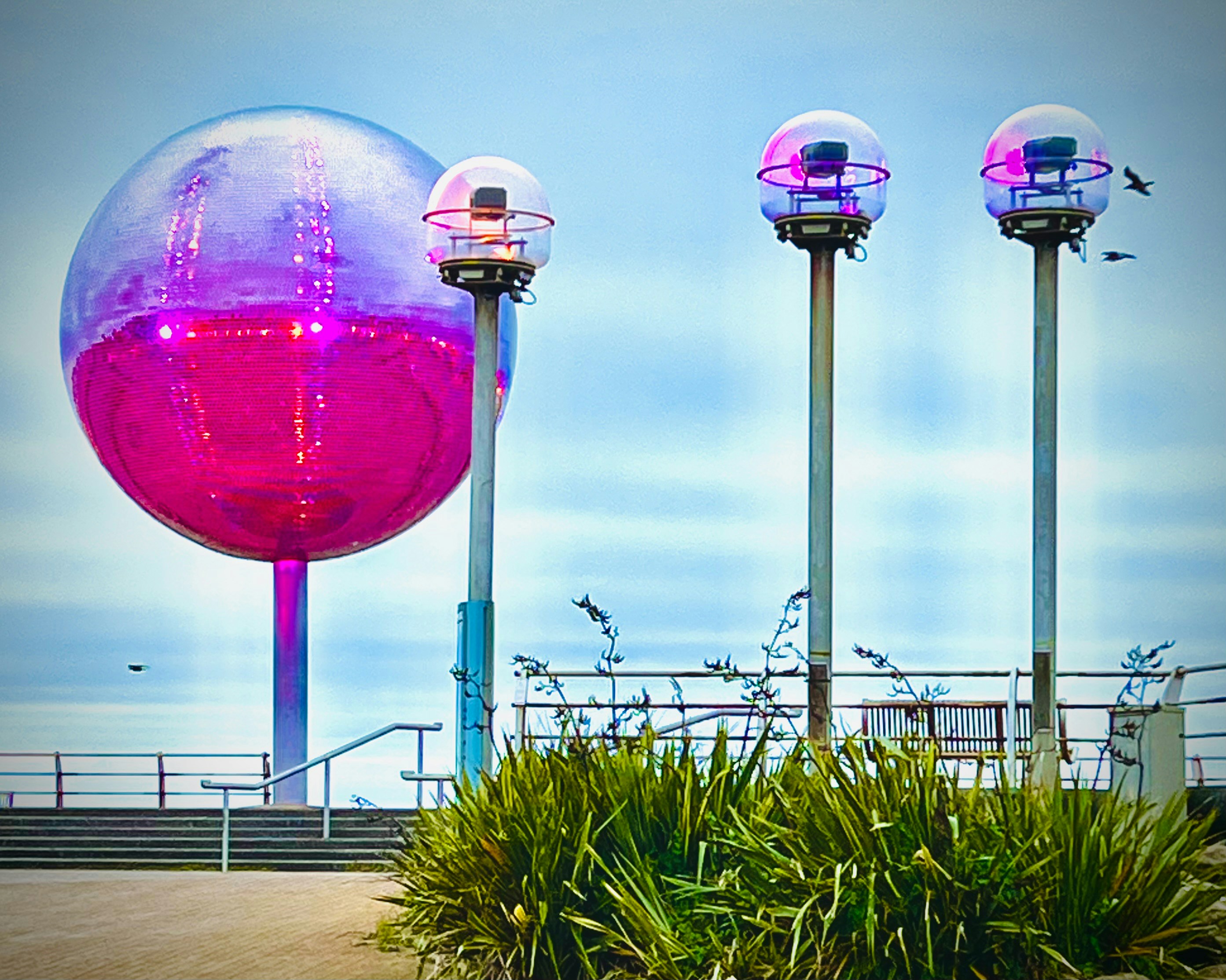Neon Orbs Over a Seaside Promenade