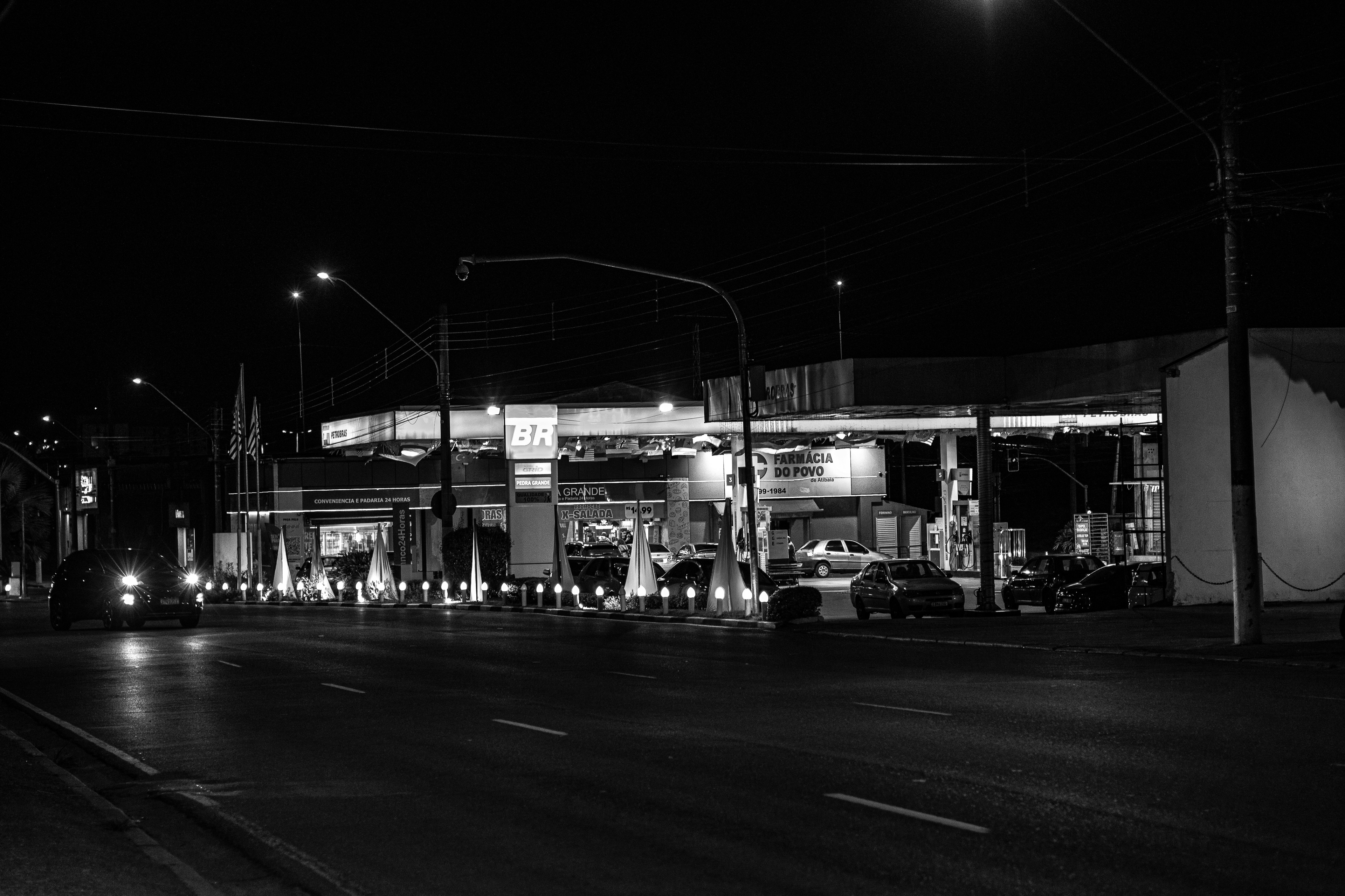 Nighttime scene at a BR gas station with cars and a pharmacy, evoking a sense of quiet solitude.
