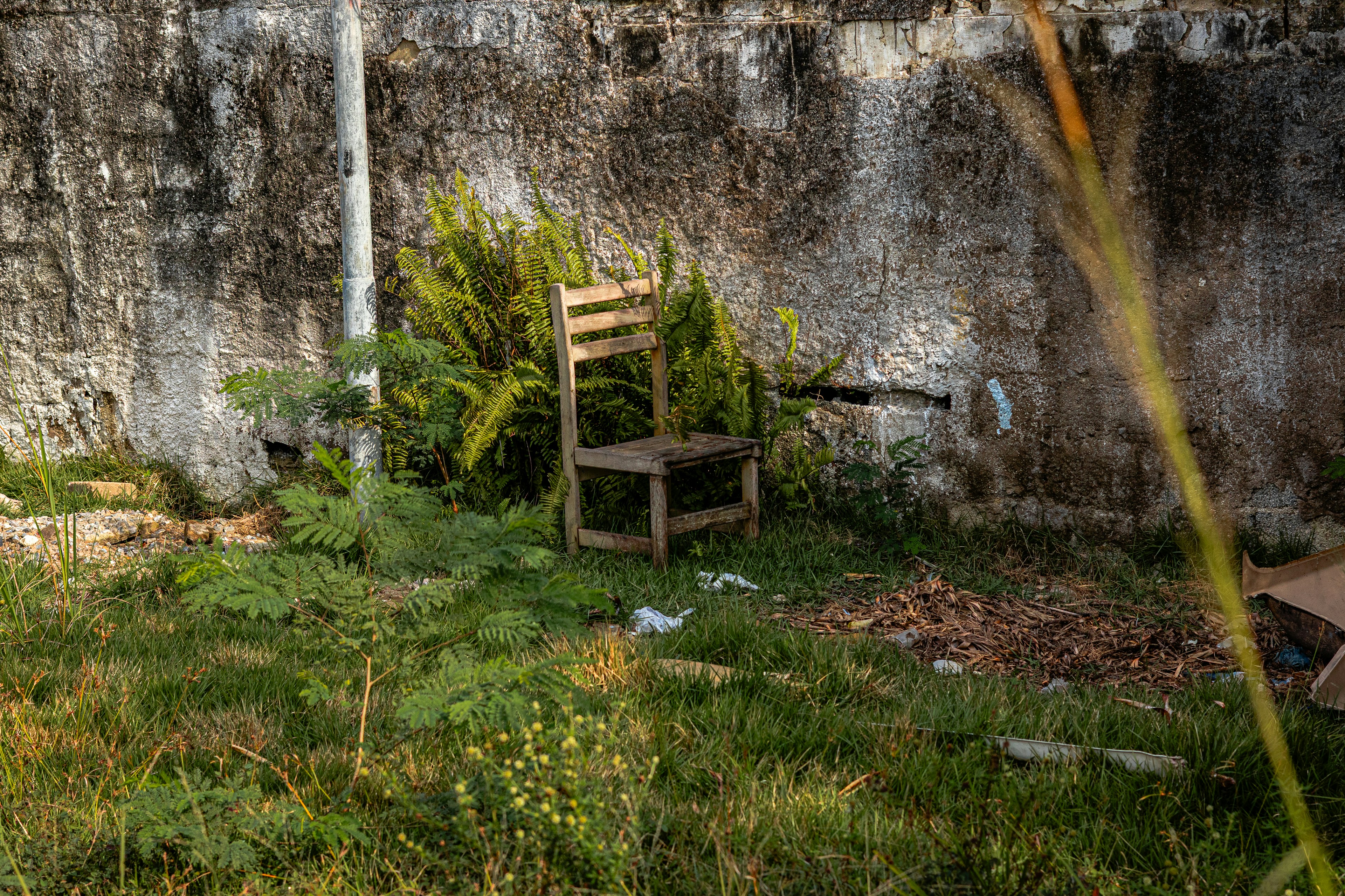 Abandoned Chair Backed by Weathered Wall