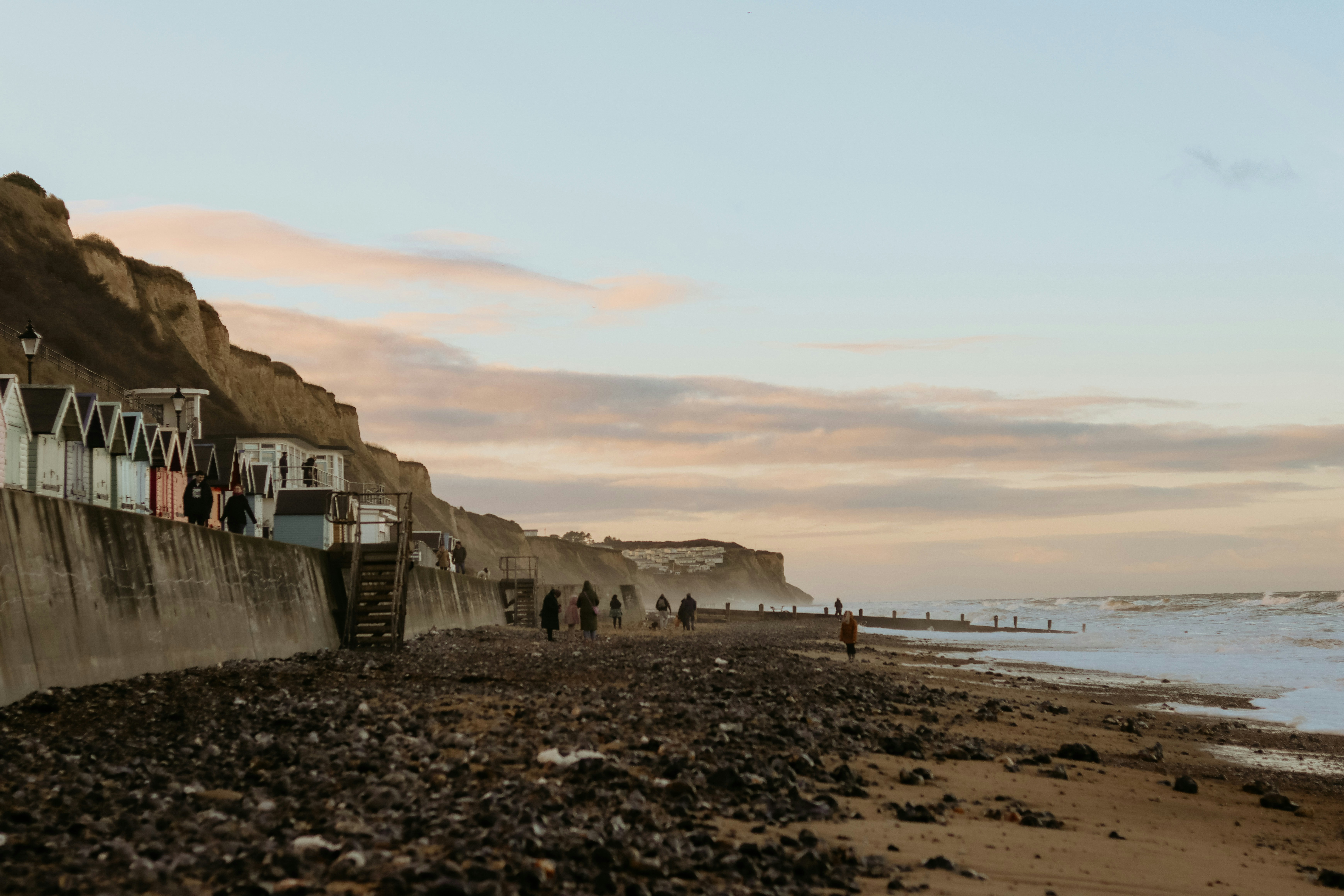Coastal Promenade at Dusk: Lifeguard Stairs and Strolling Figures