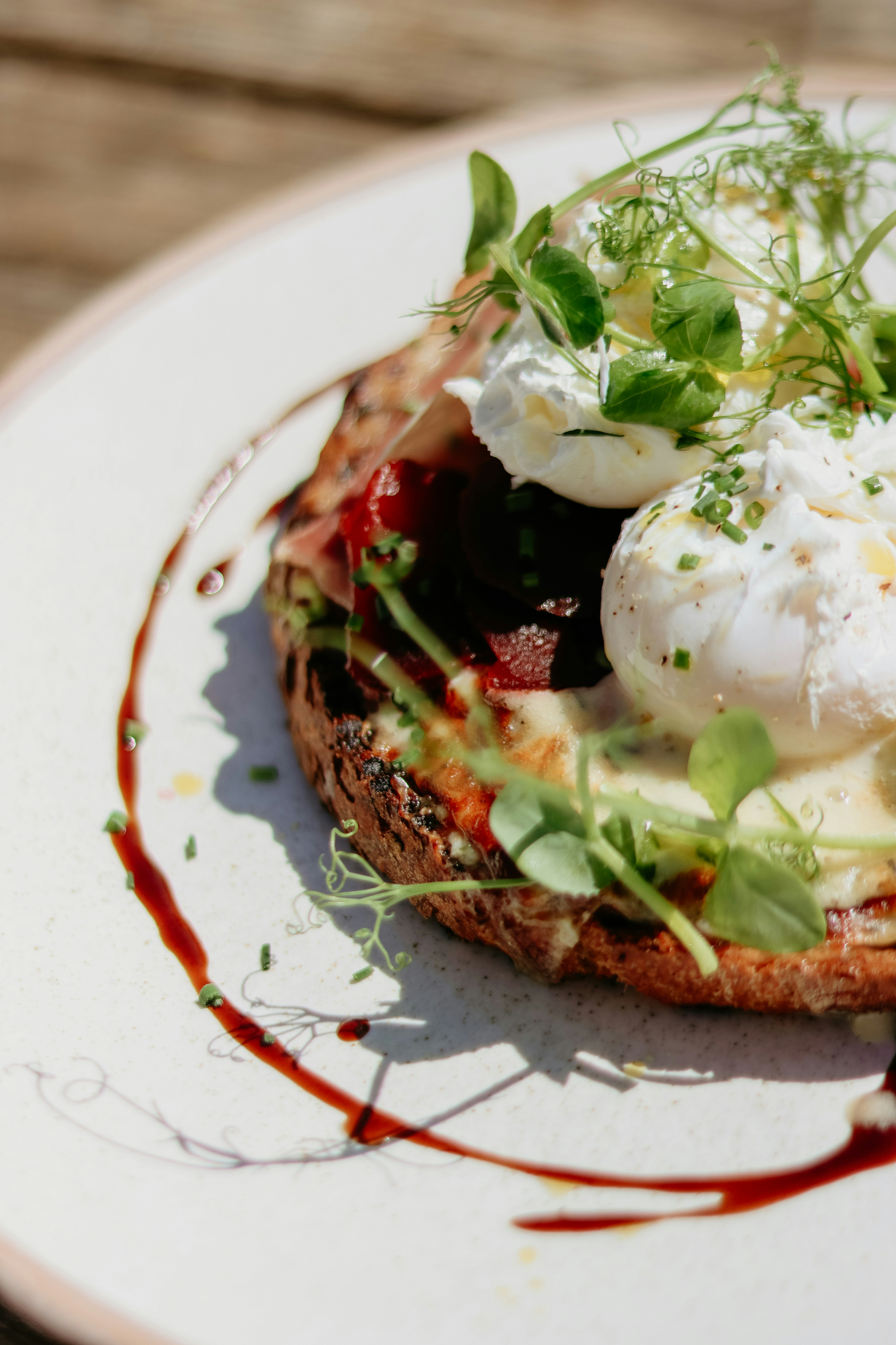 Savory Sunrise: Poached Egg Crown on Herb-Topped Toast with Balsamic Swirl