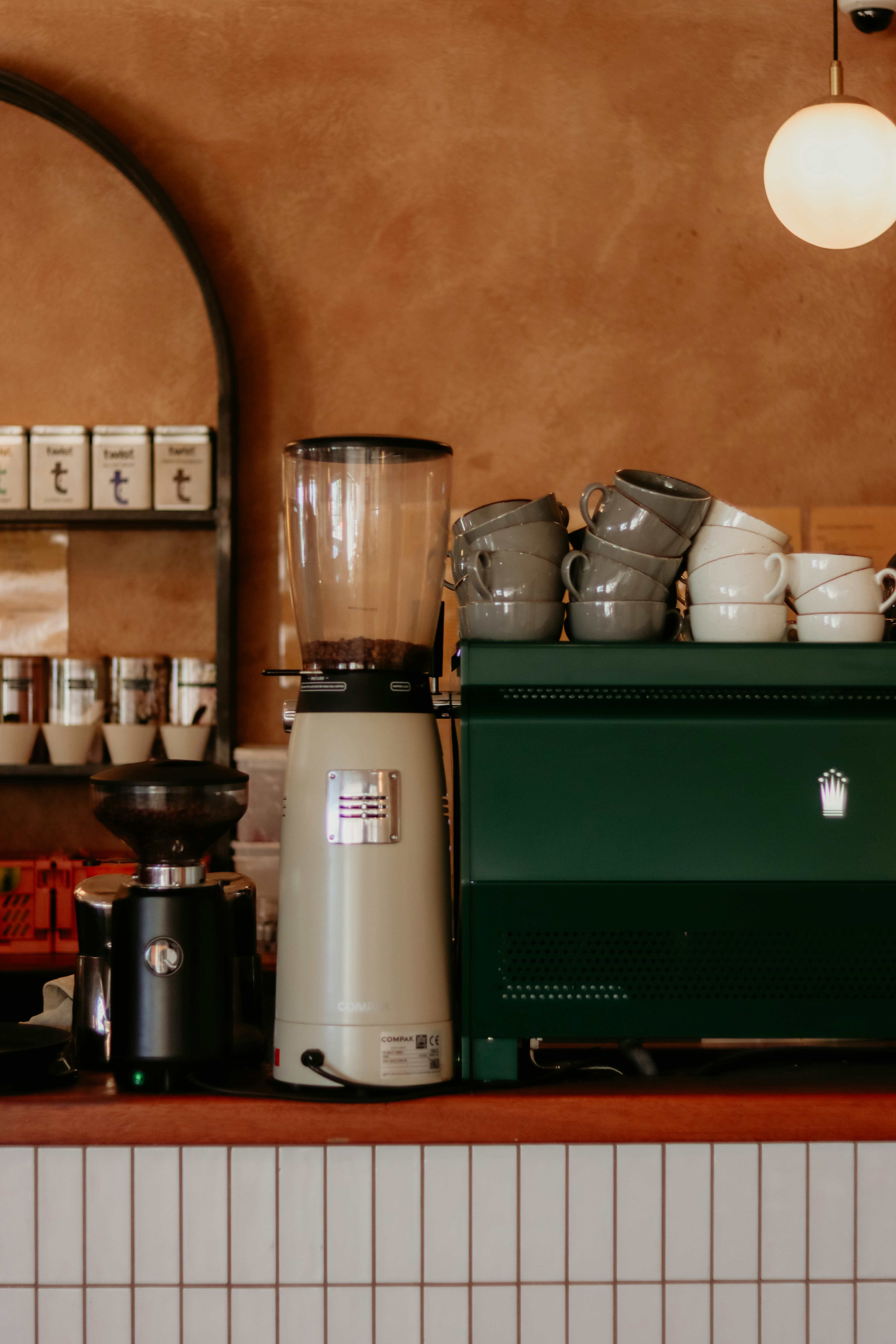 Coffee grinders and espresso machine on a cafe counter.