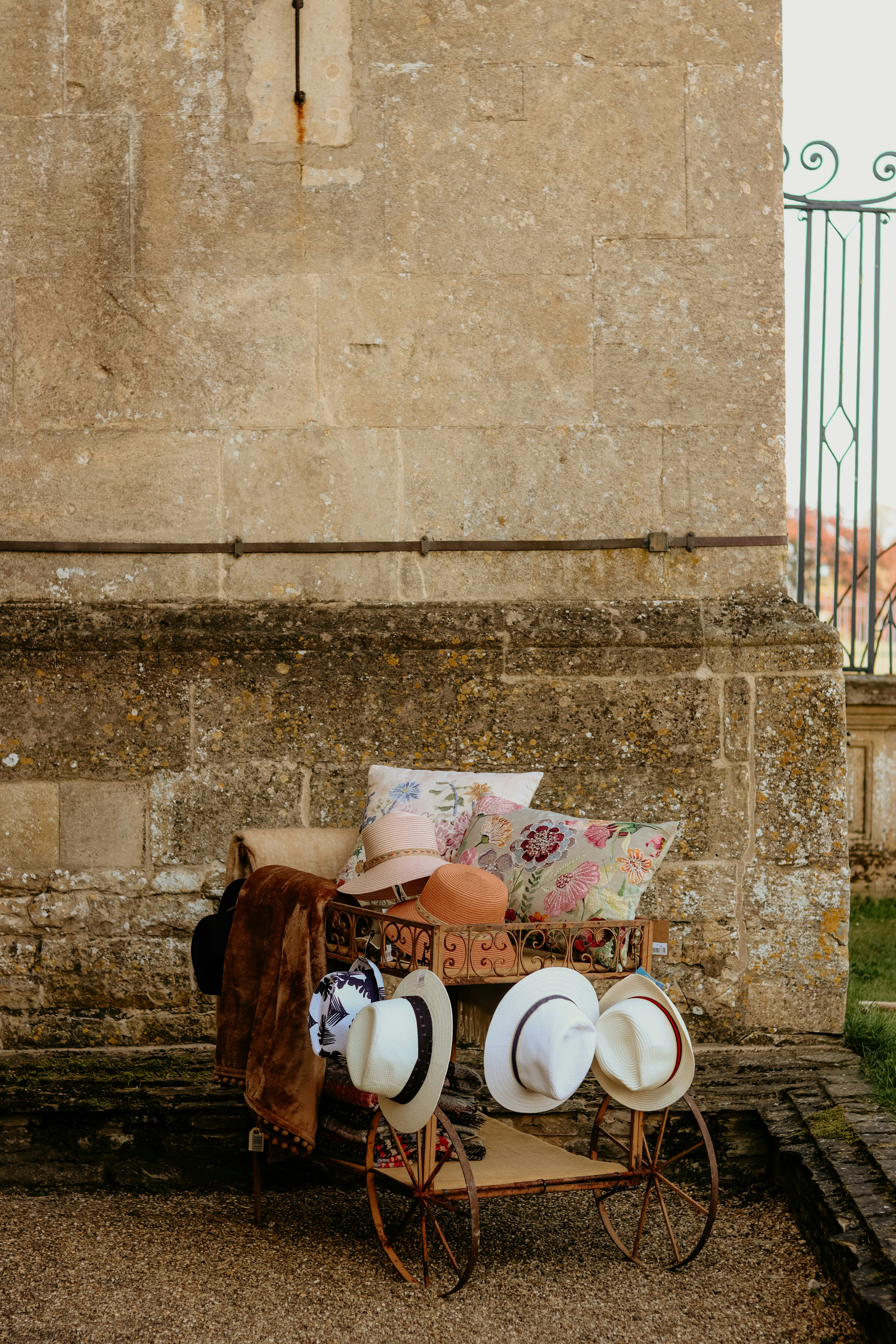 Street Cartography: Hats and Pillows Rest on a Rustic Wheel Cart