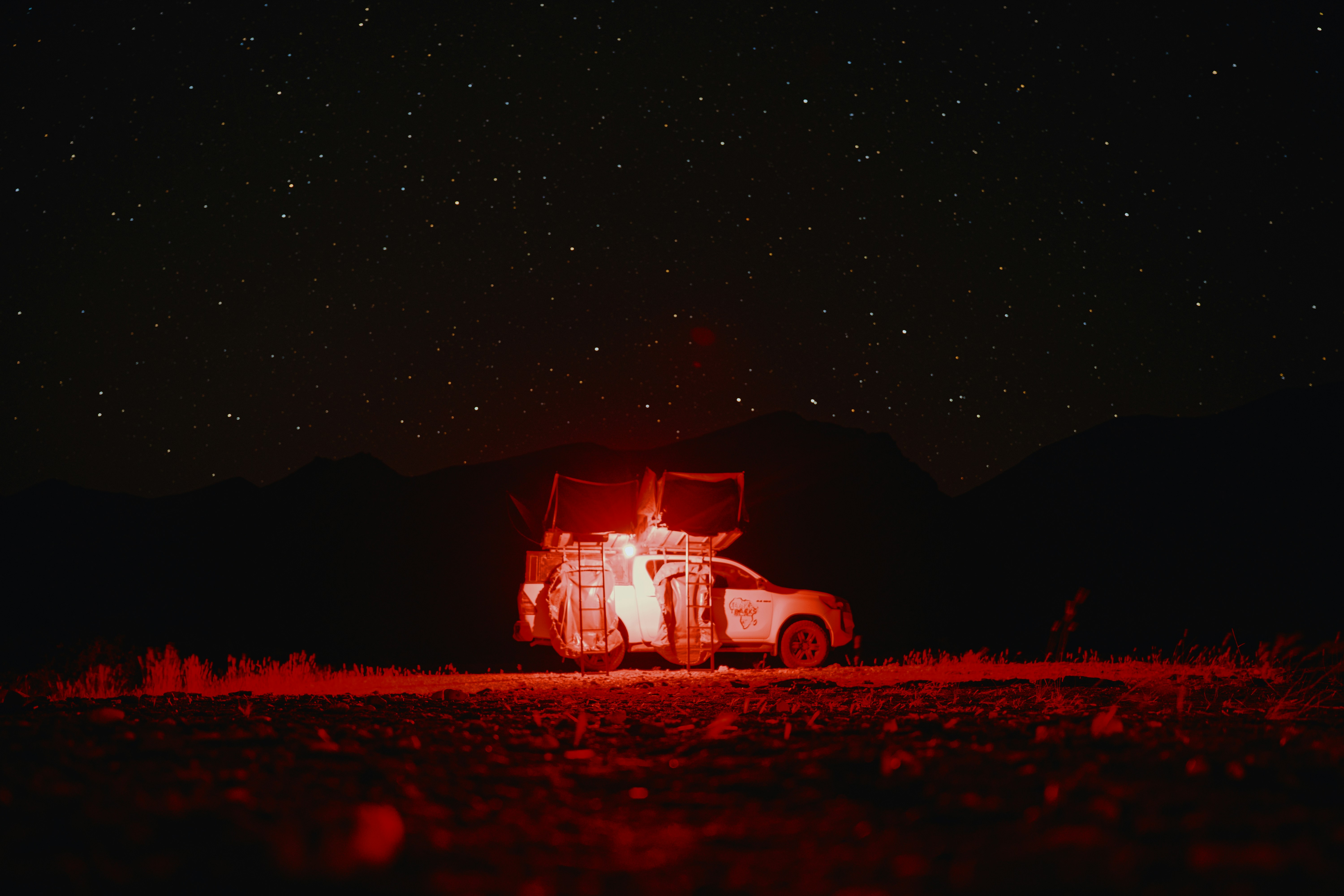 Red Solar Ranger: Nighttime Vehicle Standstill Under Starlit Sky