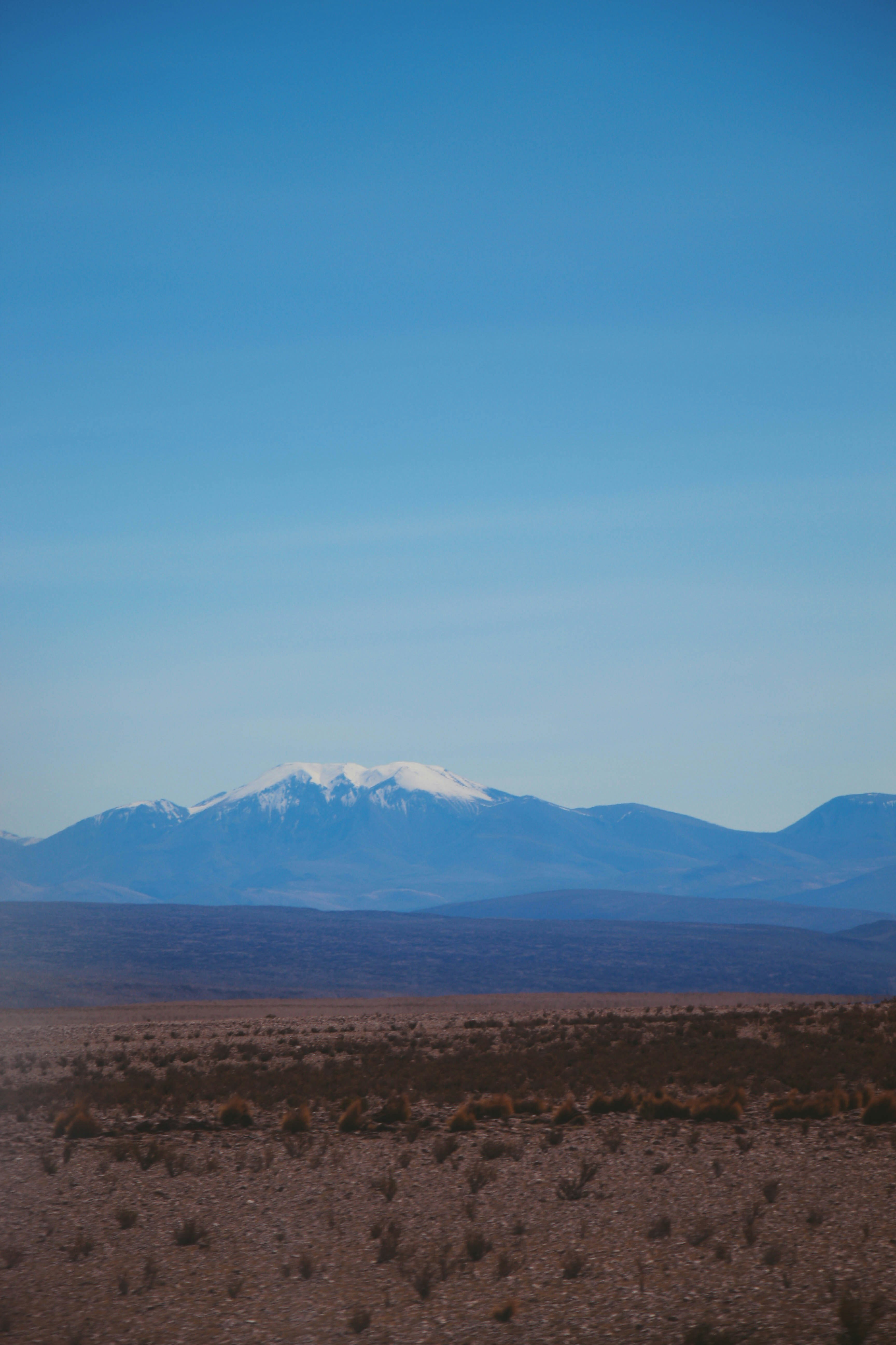 Snow-capped Peak Above Desert Basins at Distant Horizon