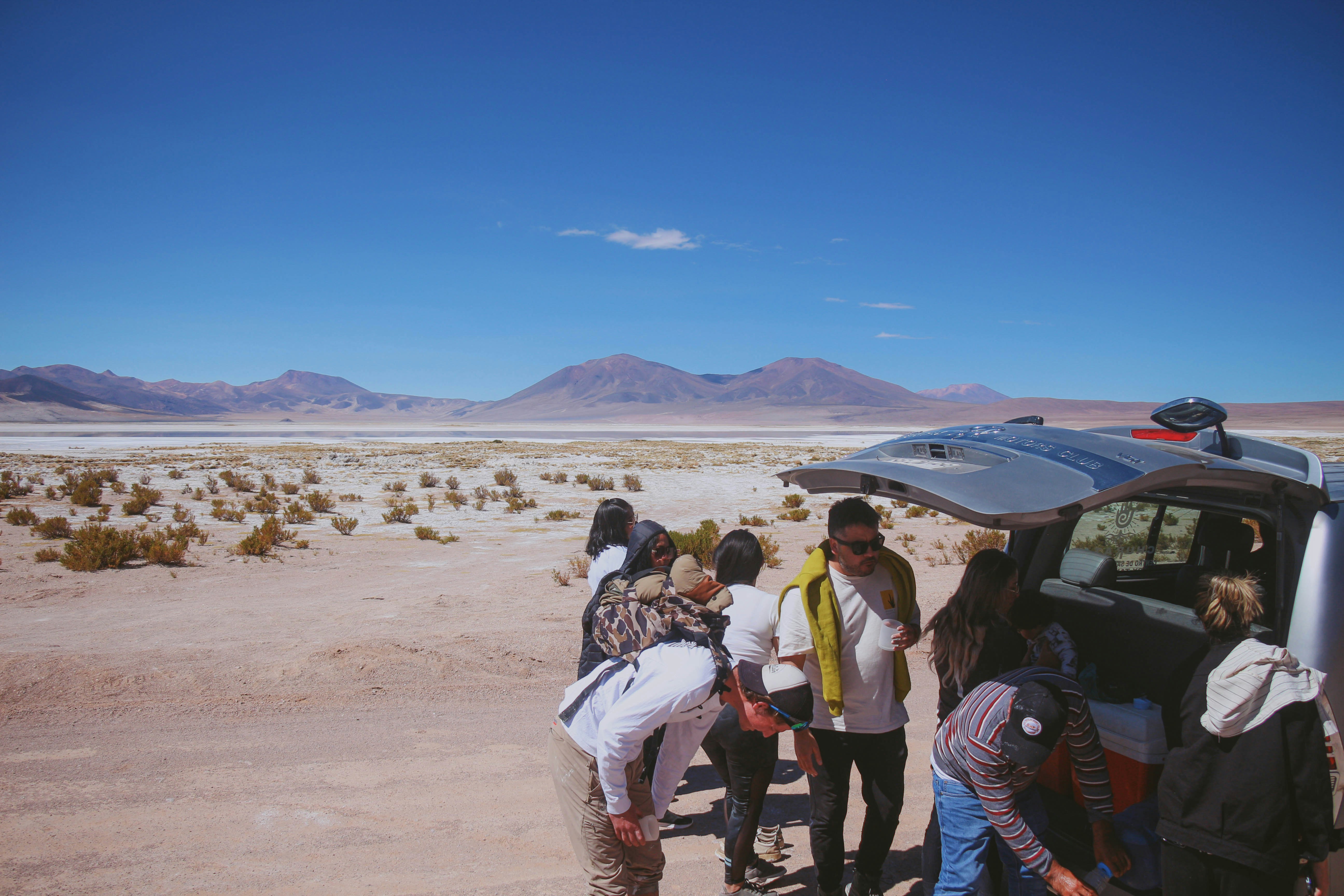 Desert Meet-up: Travelers Huddle by an Open Hatch