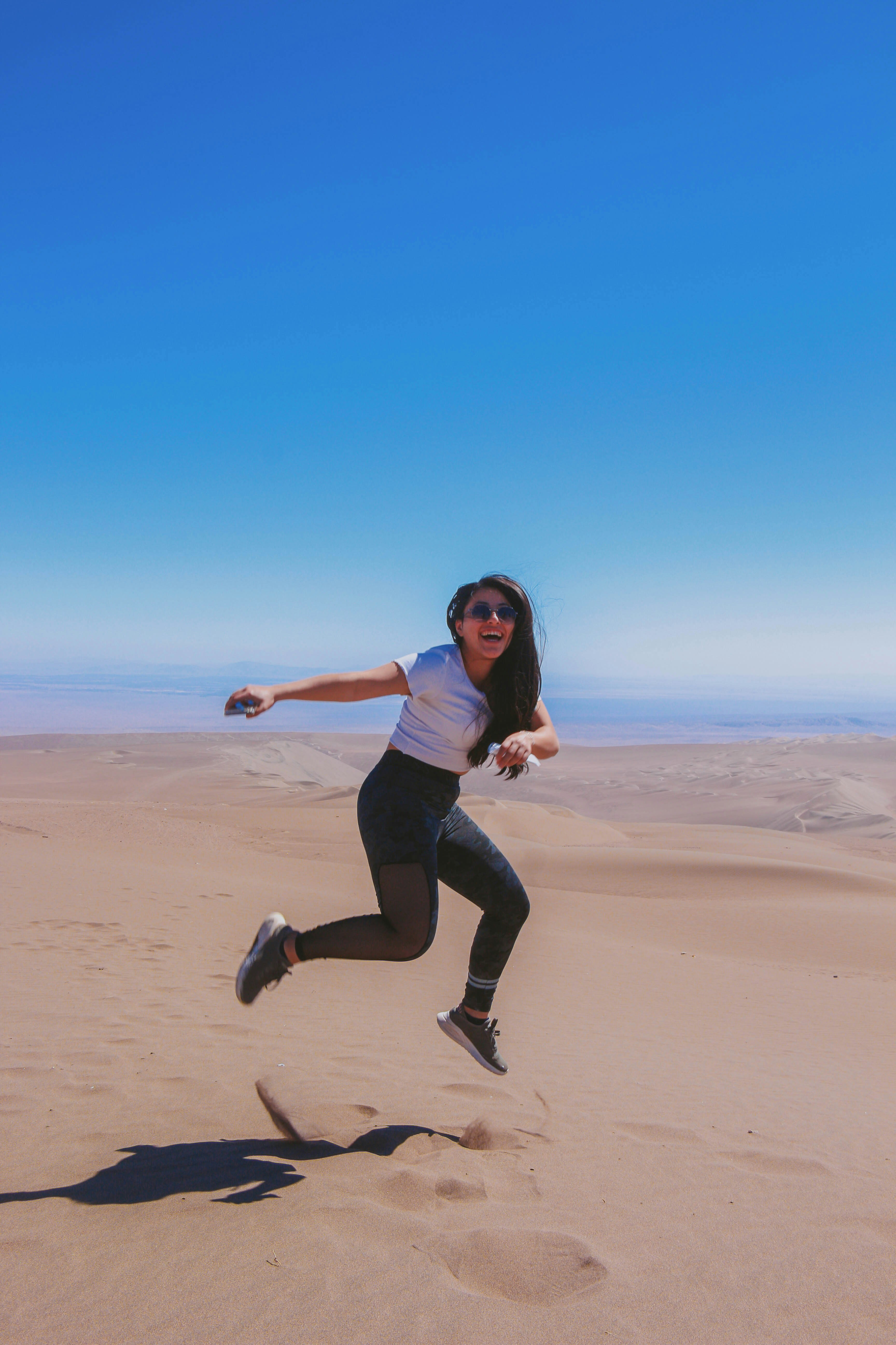 Desert Jump: A Girl in Motion Over Wind-Swept Dunes