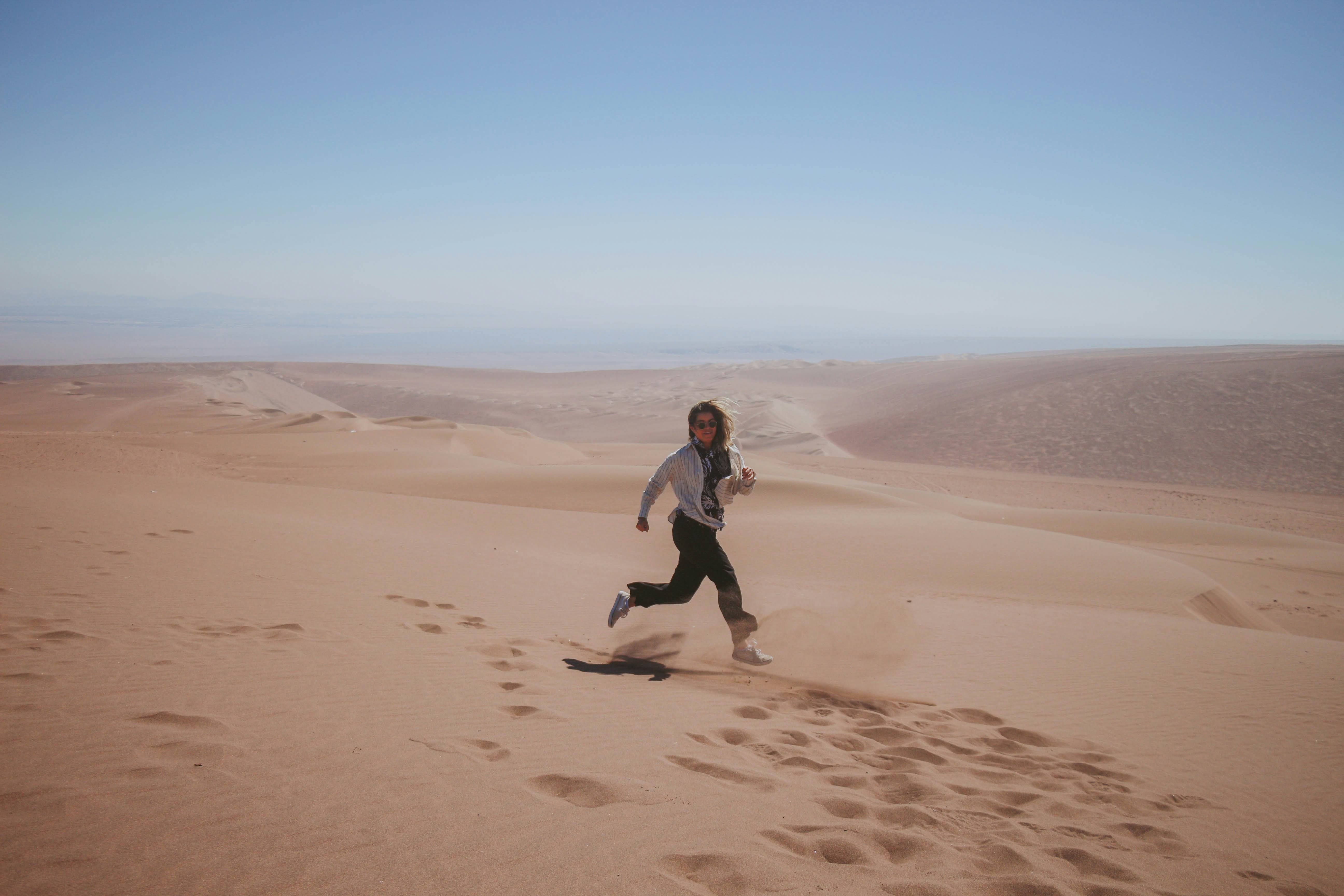 Footprints of Freedom: A Runner Carving Through Desert Dunes