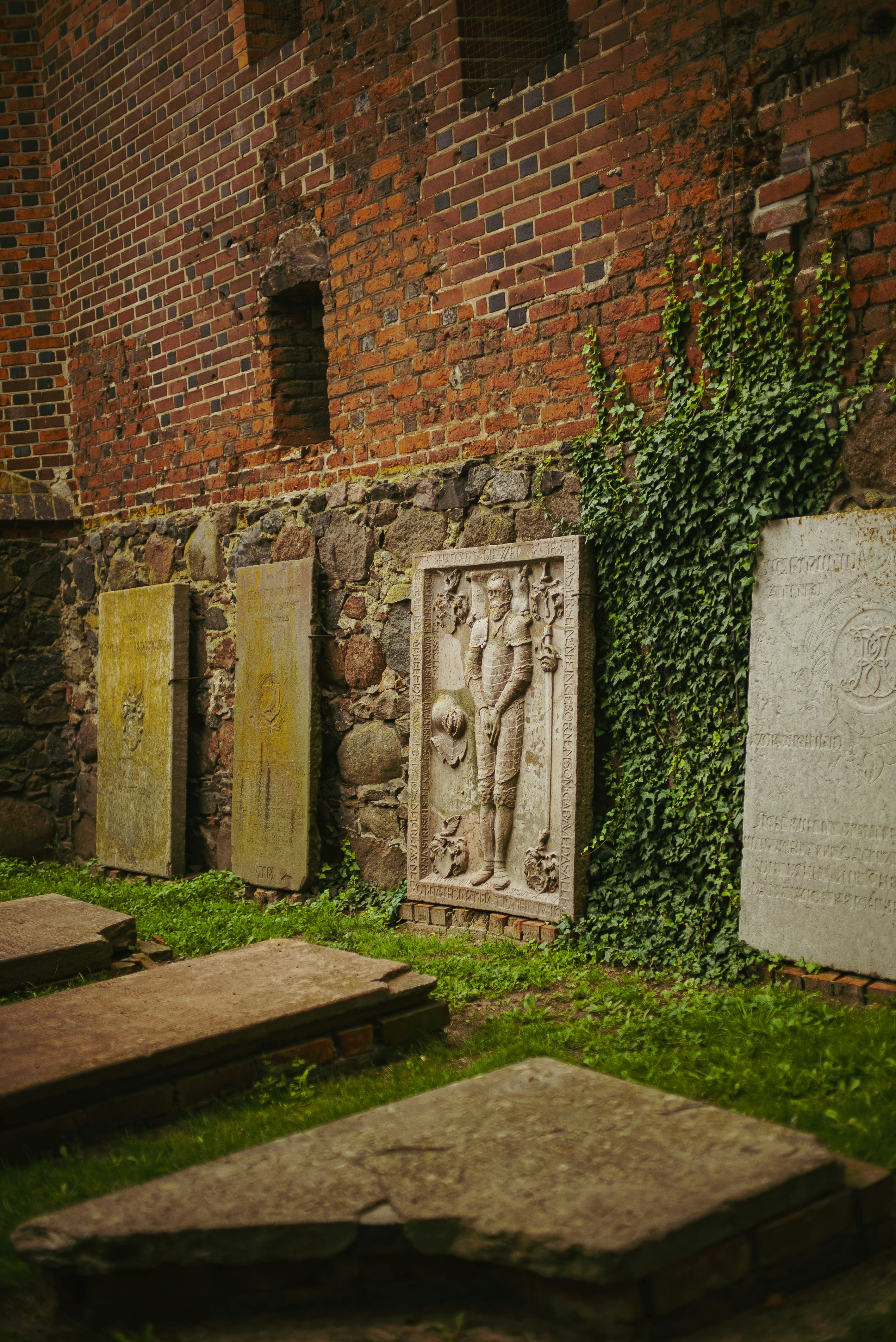 Weathered Memorials against a brick wall