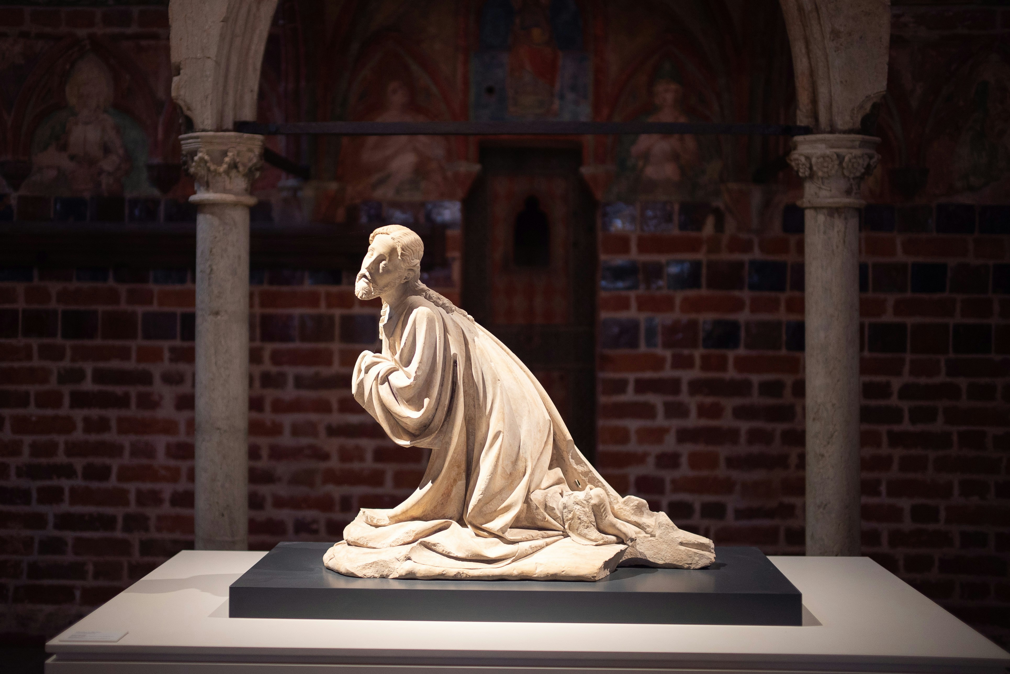 Solitude in Marble: A Kneeling Figure on Display