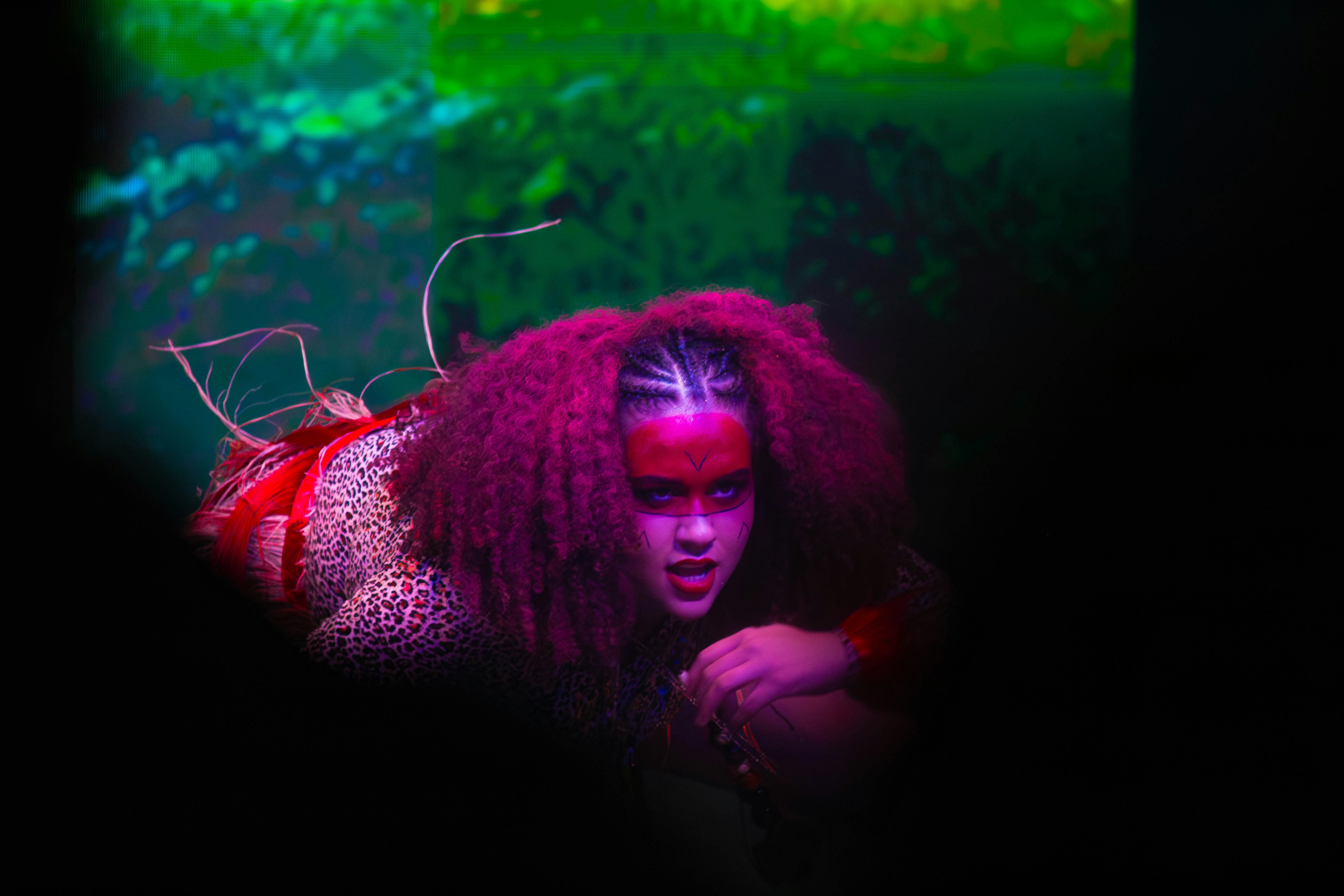 Hidden Spotlight: Neon-lit Performer emerges from the Fringe