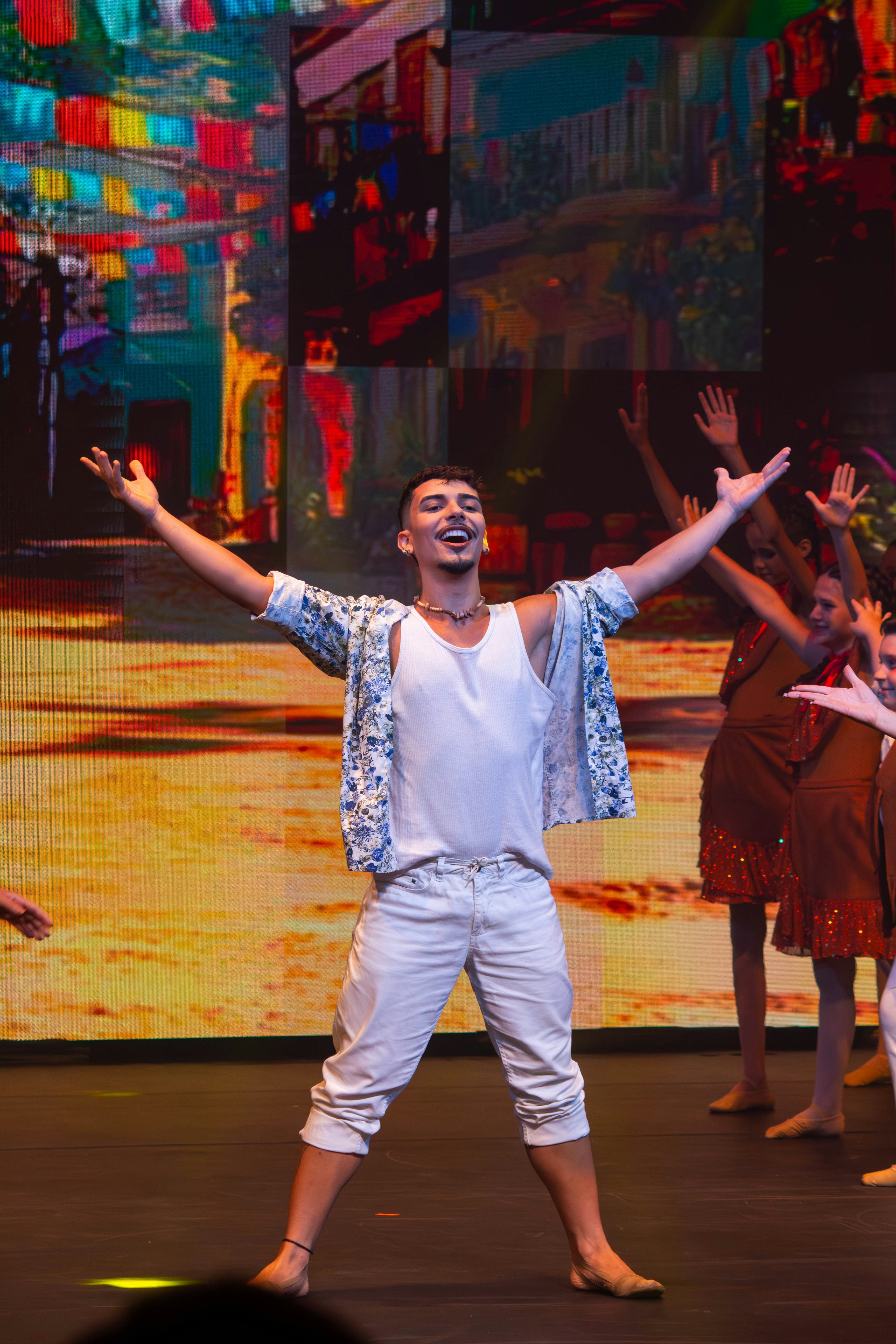 Joyful Spotlight: Dancer Opens with Arms Wide in Vibrant Stage