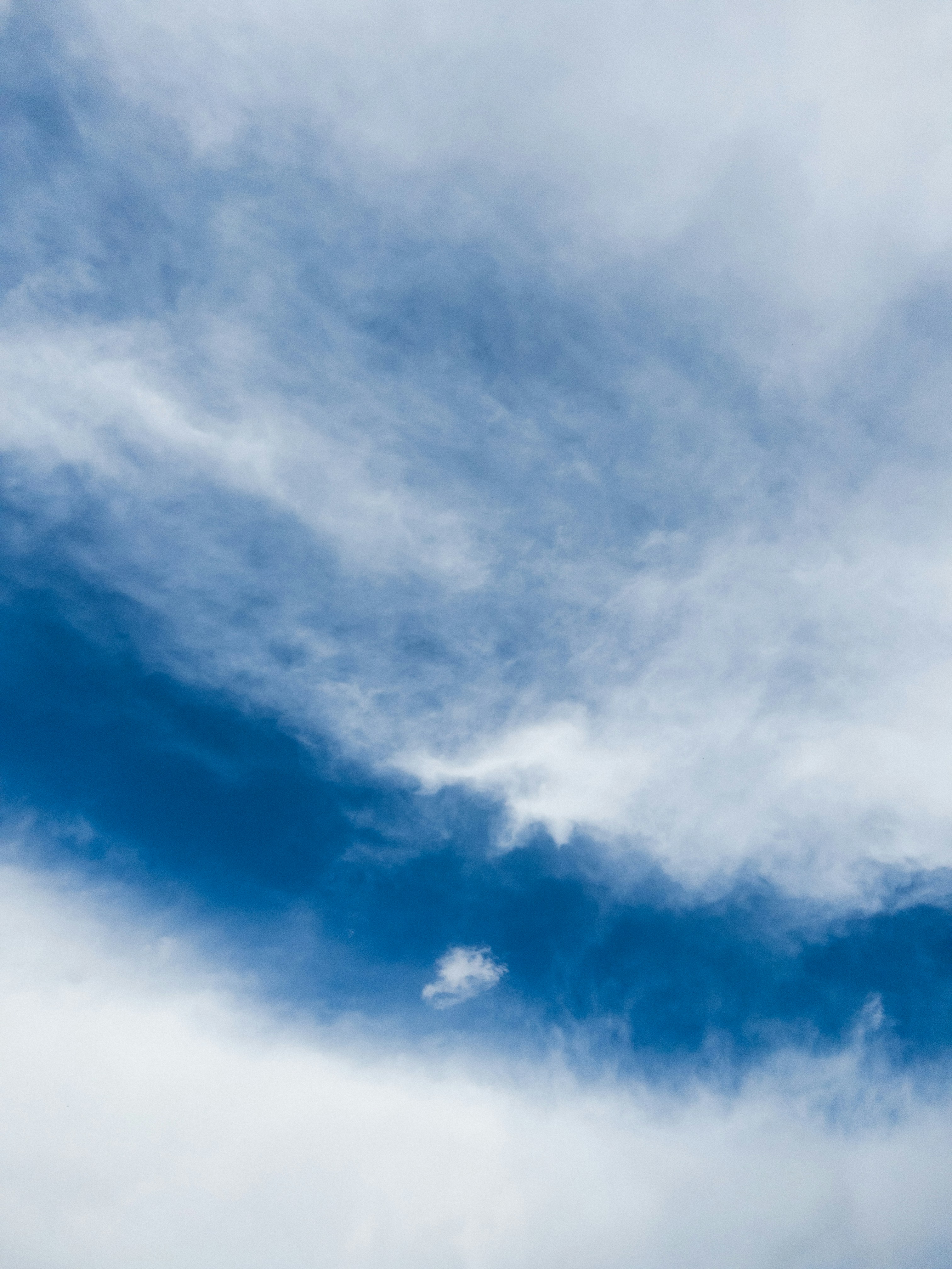 Vibrant blue sky peeking through white clouds.