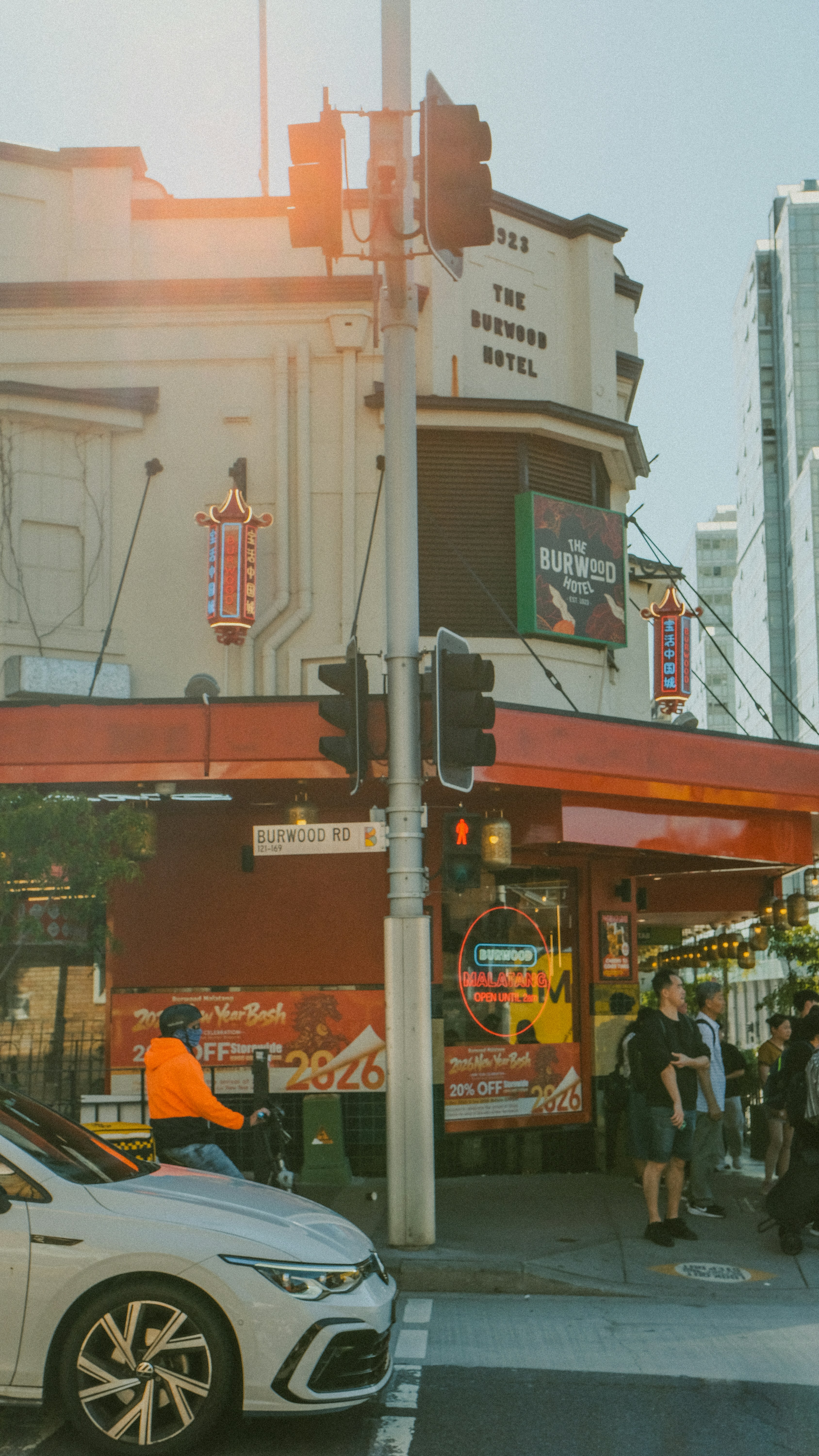 Burwood Corner: Neon Signs and Pedestrian Pulse on a Sunny Street
