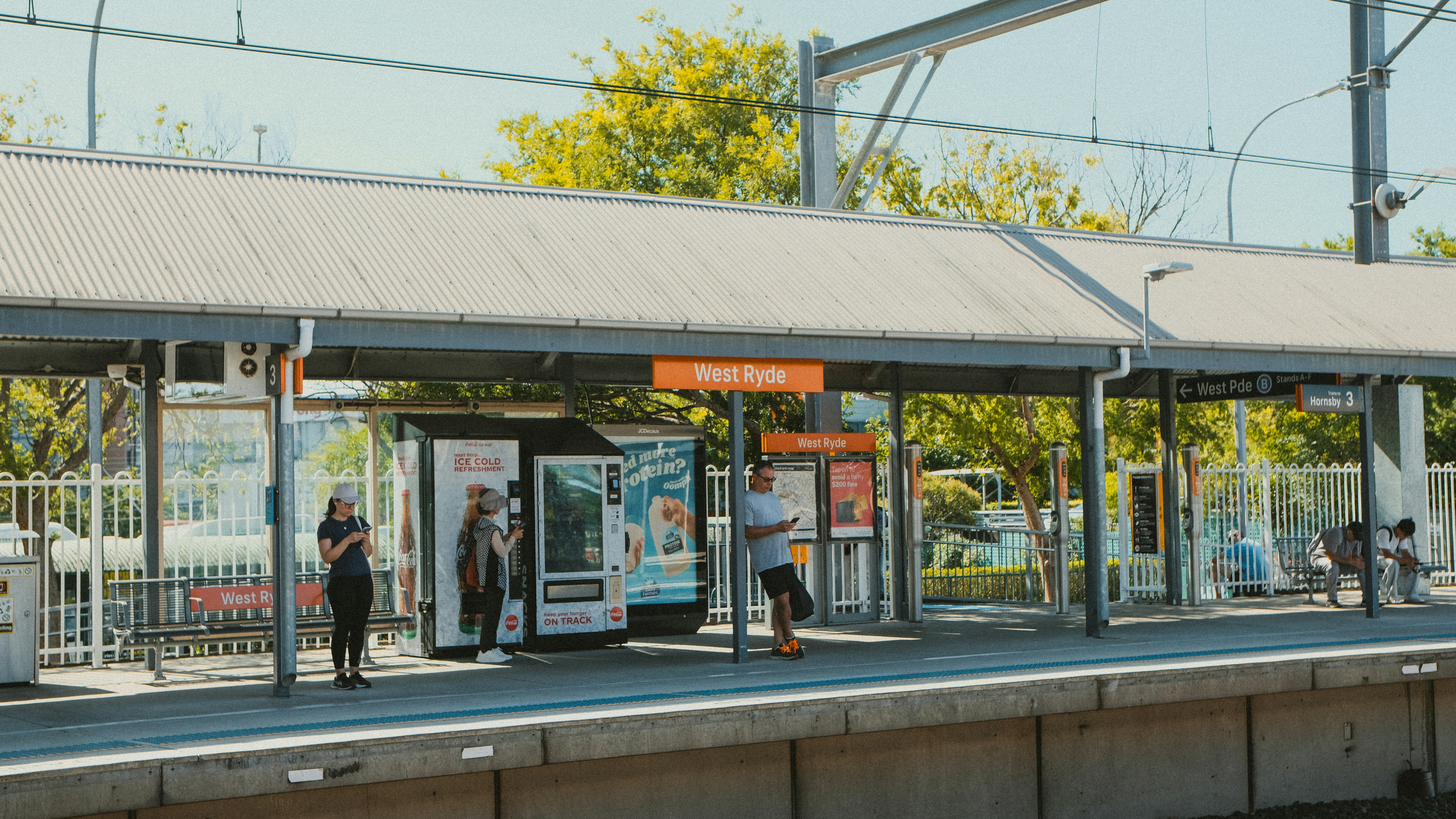 Quiet Platform at West Ryde: Vending Booths and Passengers in Morning Light