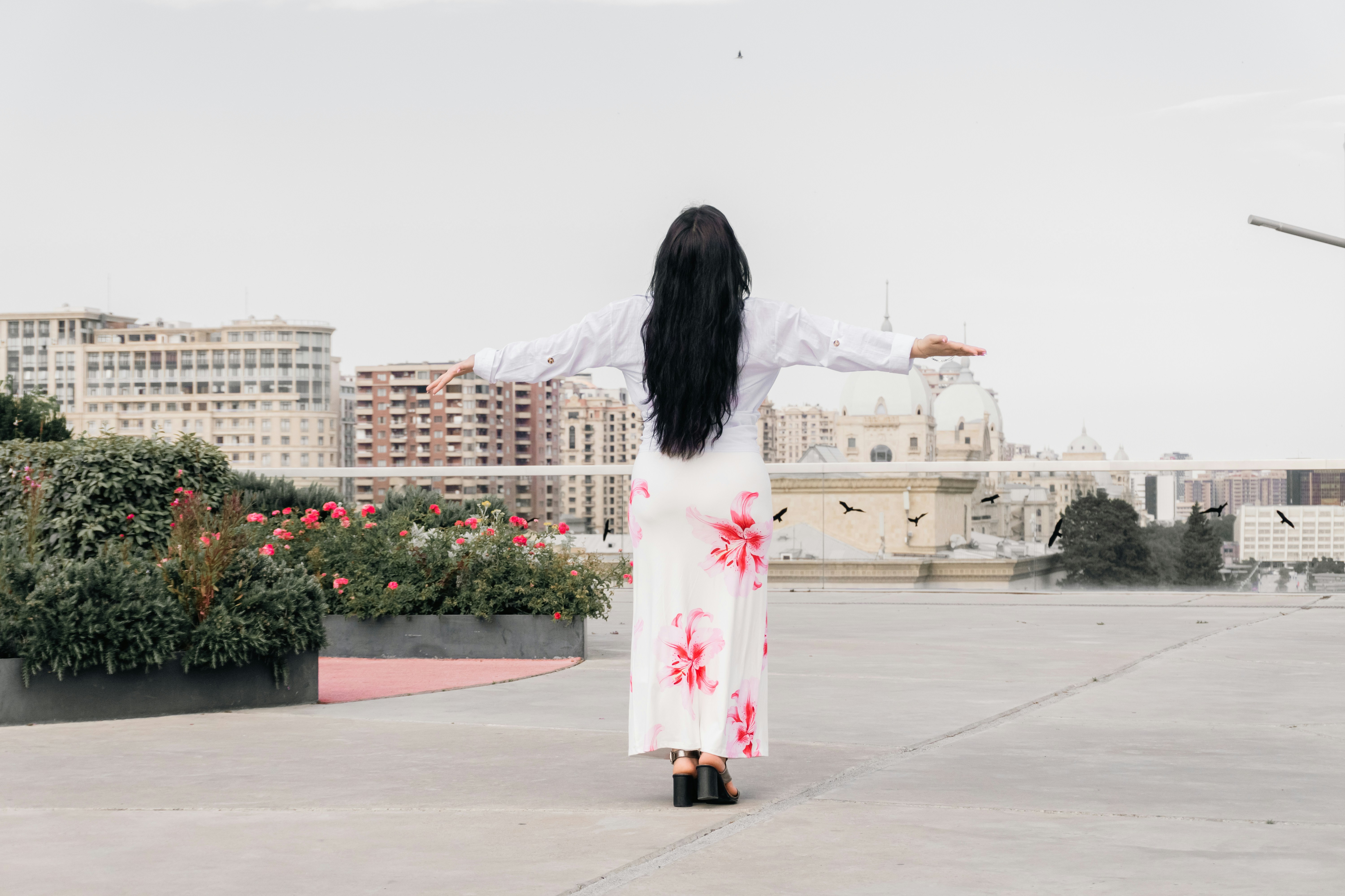 Silhouette of Freedom: A Woman in White with Floral Veil on a Rooftop