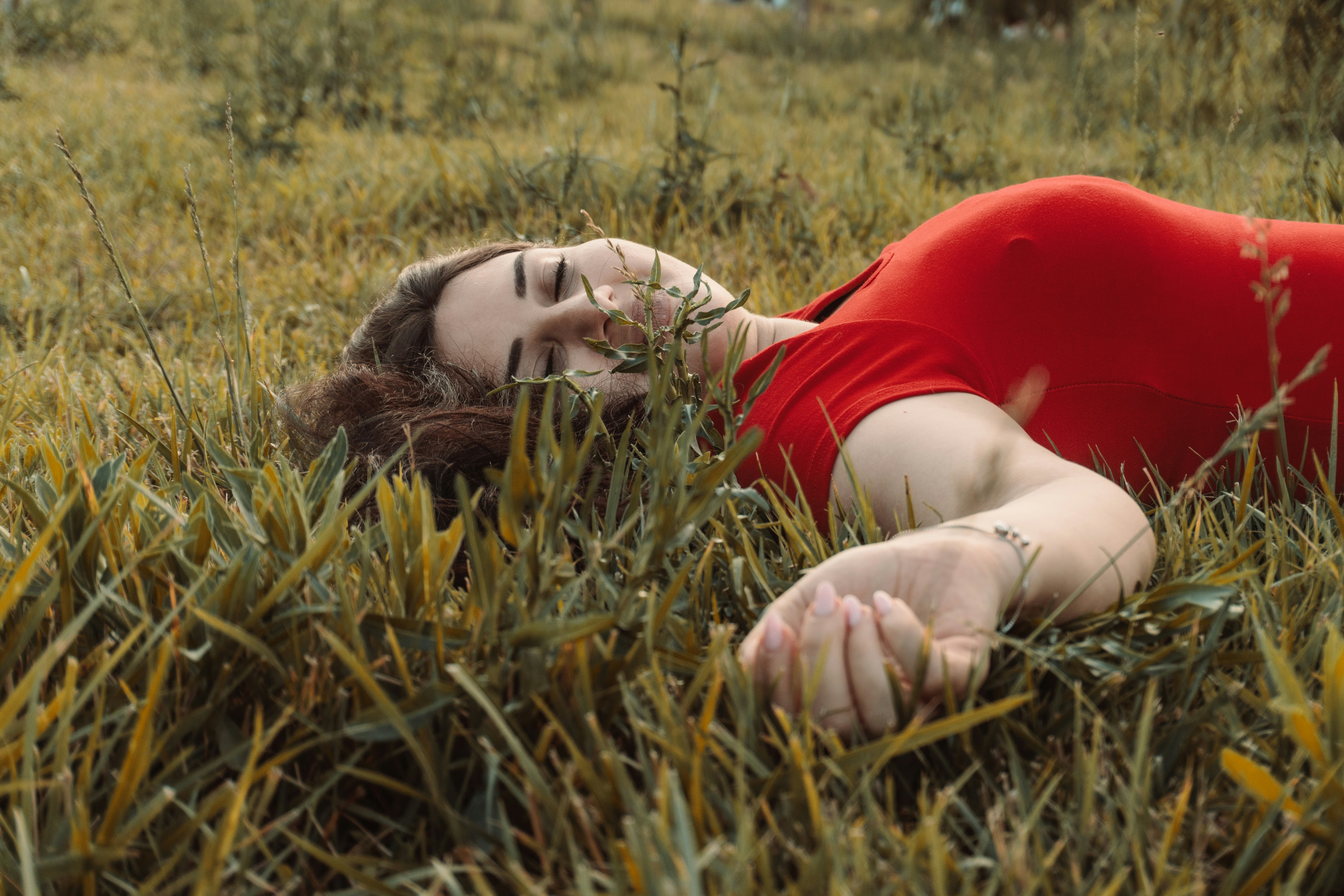 Red-clad Stillness: Woman in a Meadow Bed