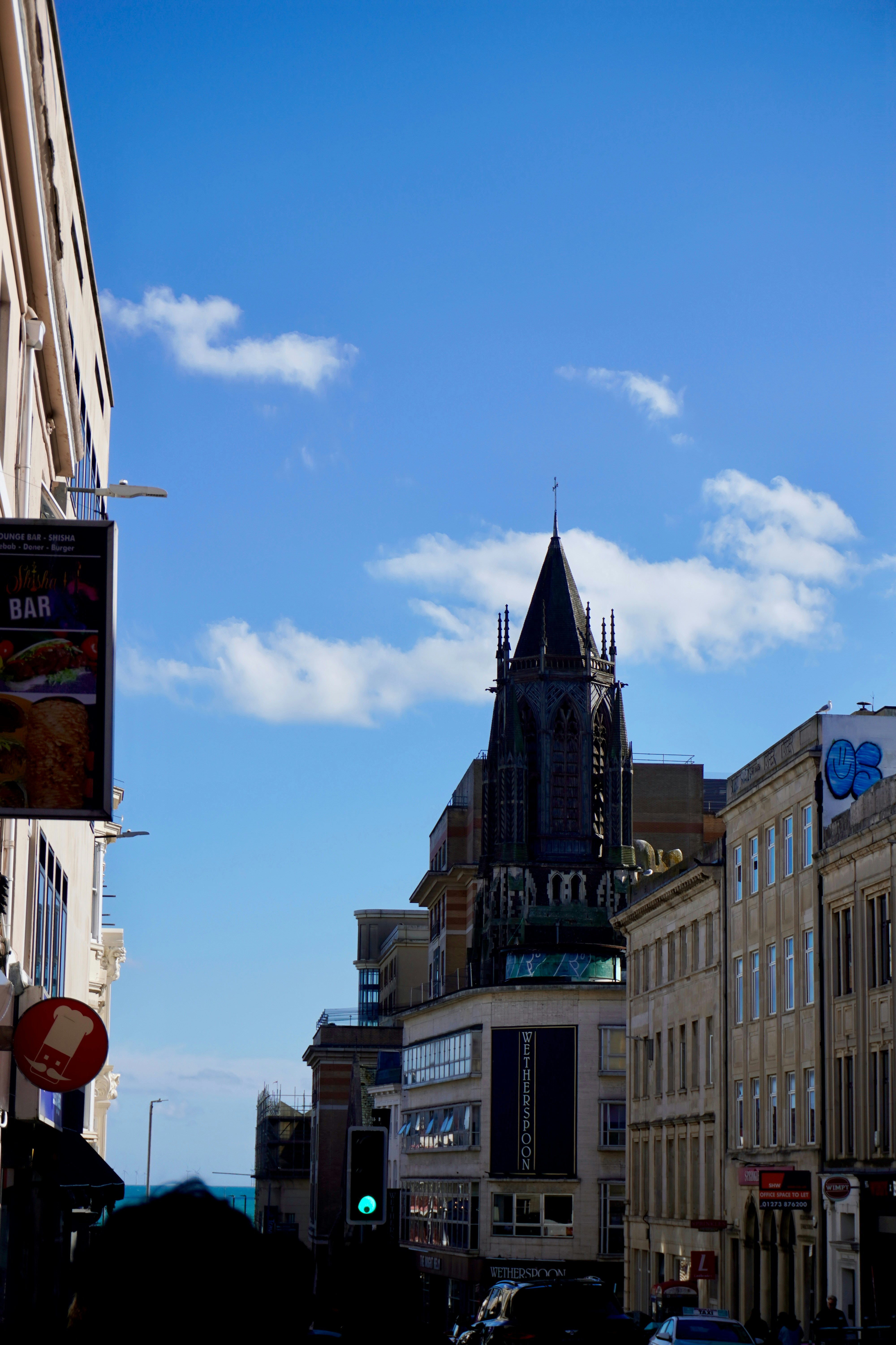 St. Gothic Spire Rising Above a Sunlit Street of Navan
