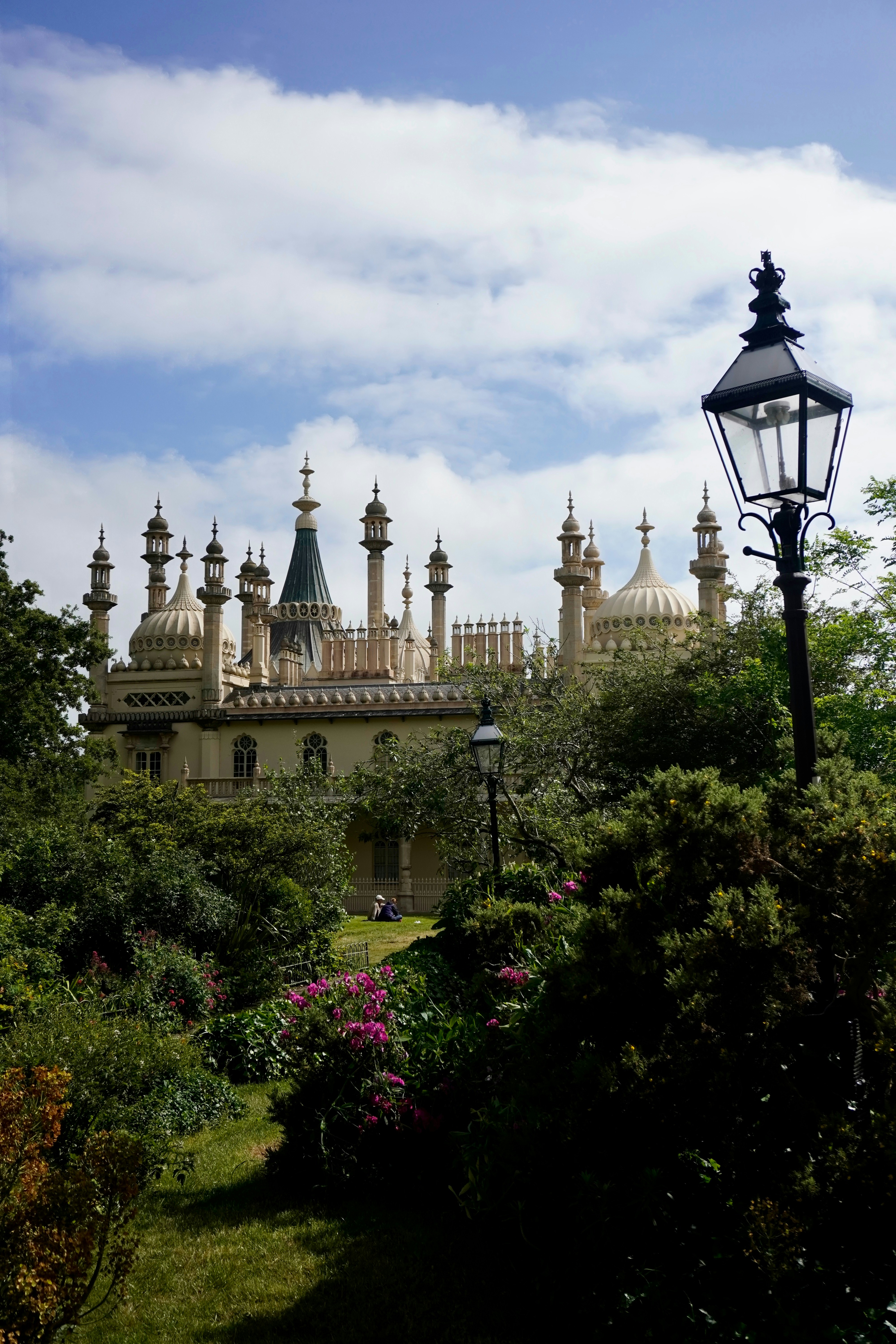 Ornate domes and lanterns rise over a manicured garden