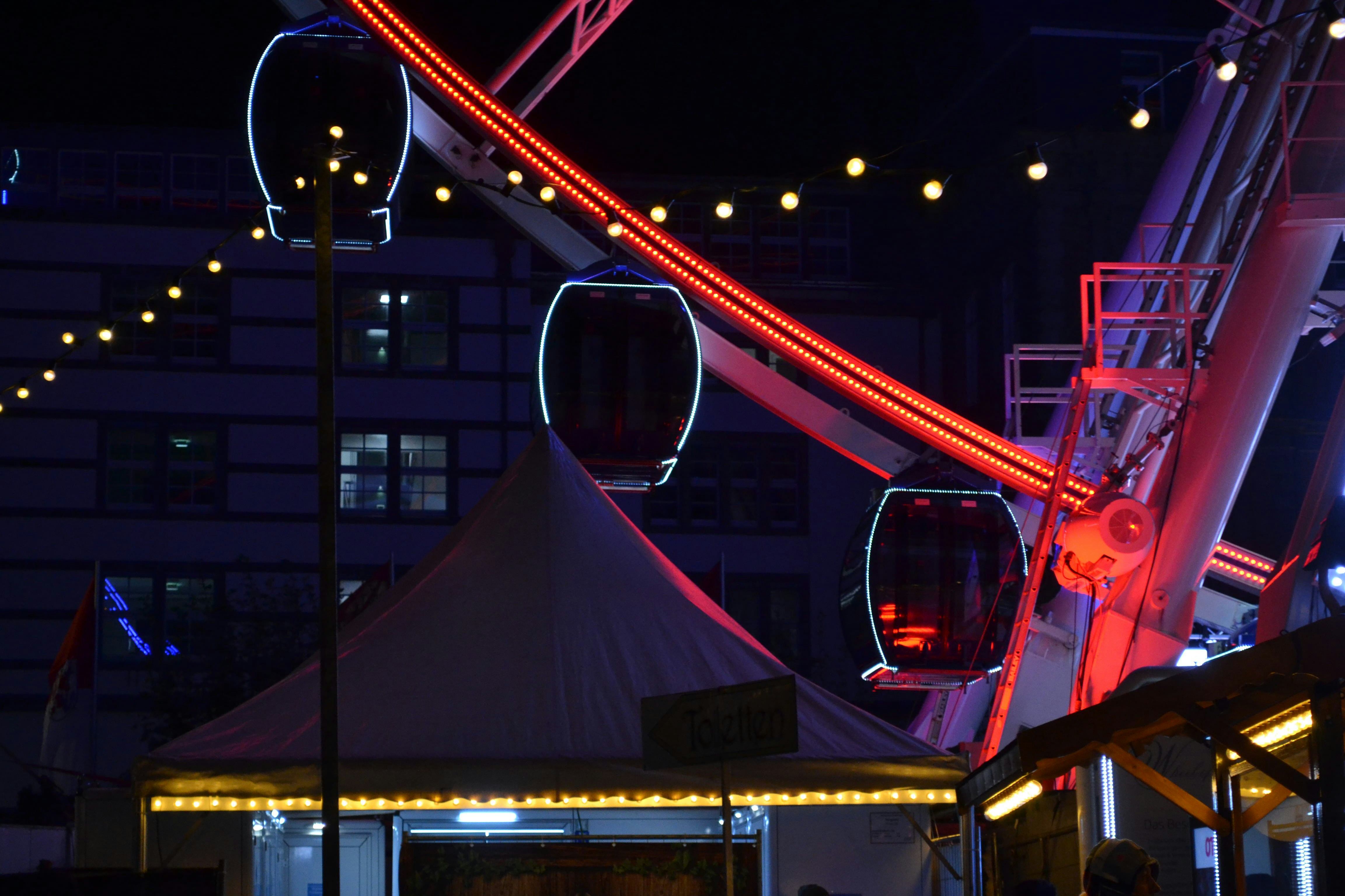 Night at the Ferris Wheel: Neon Geometry Above a Canopy
