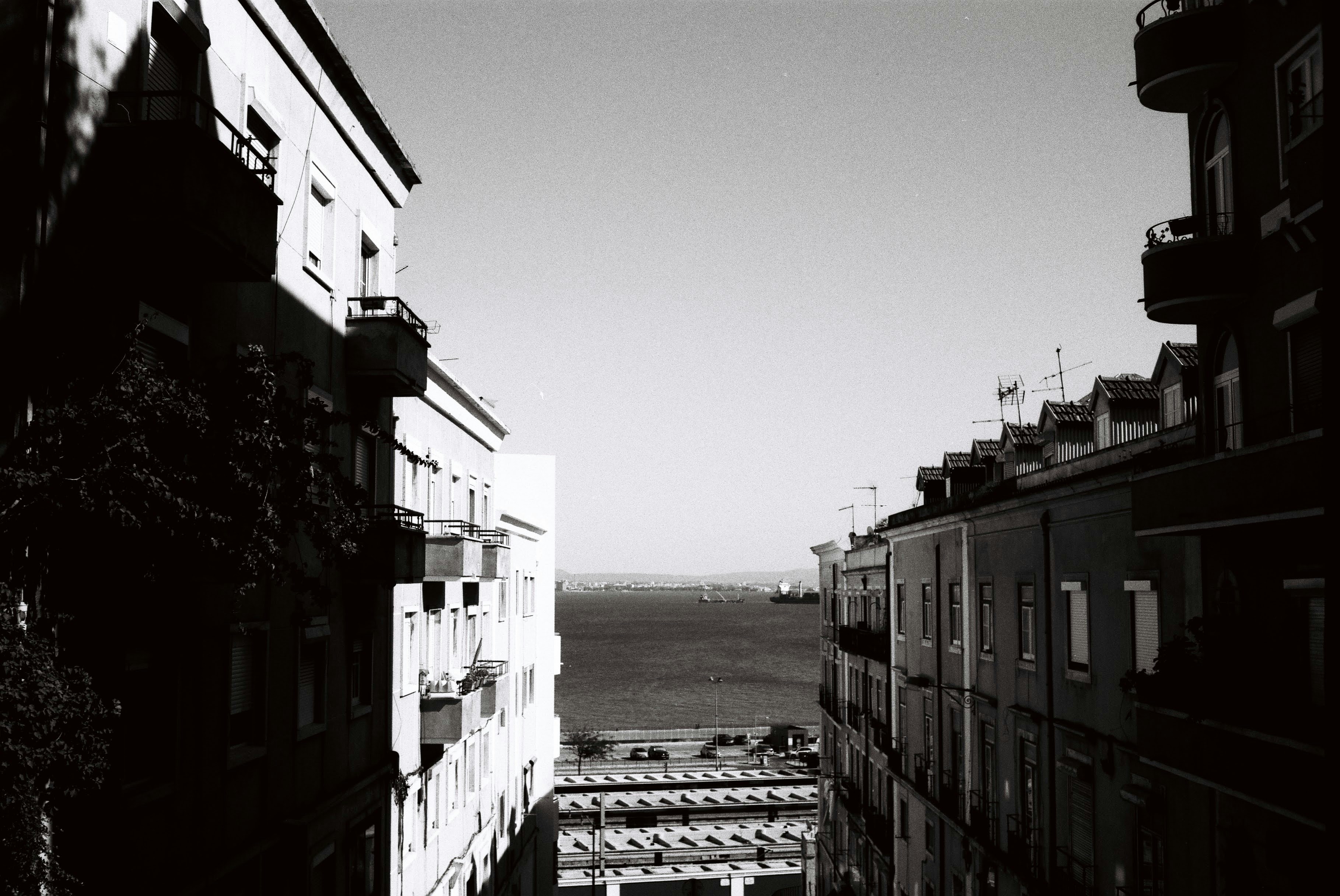 Narrow daylight between alleys toward distant harbor