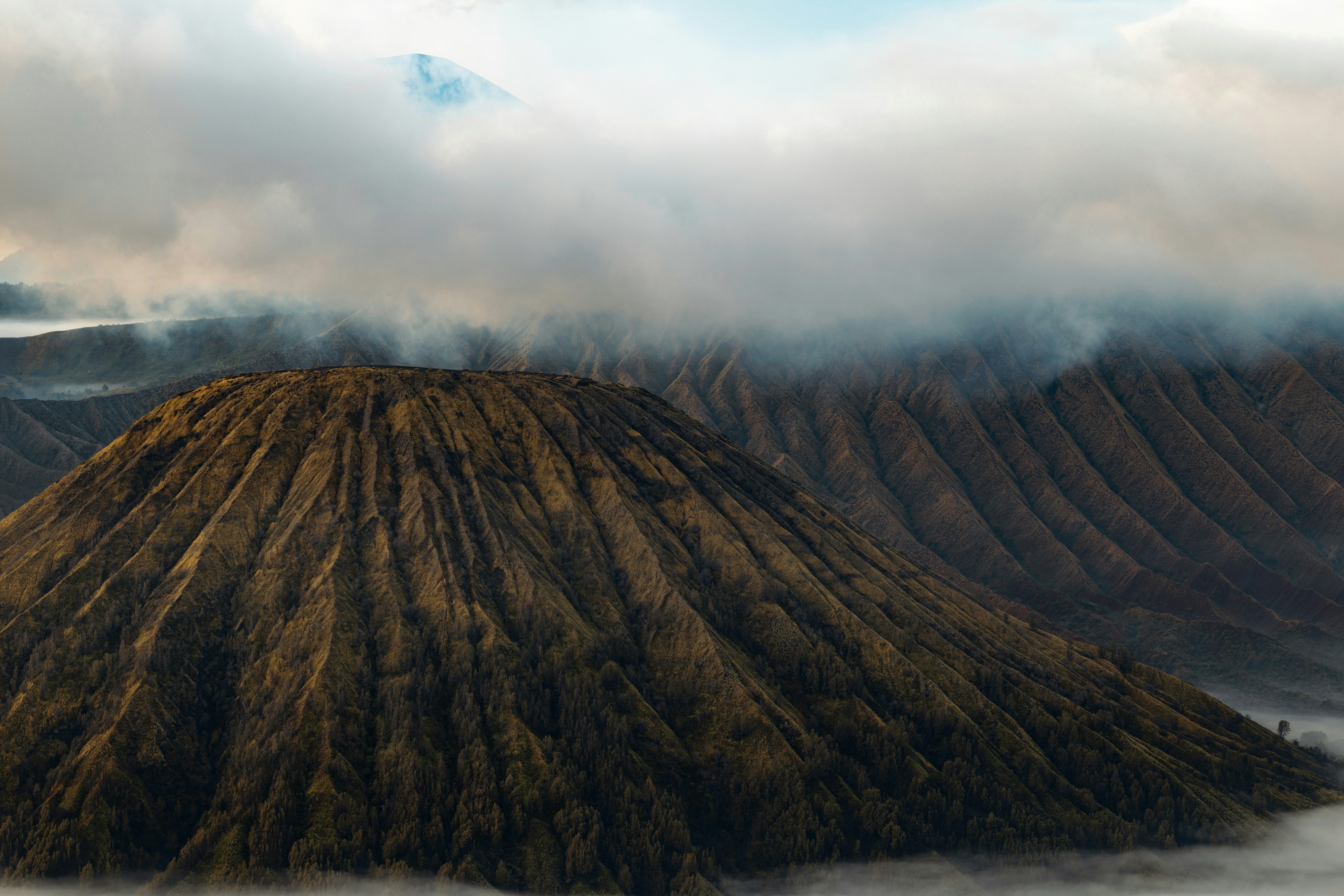 Volcanic landscape with peaks emerging from clouds.