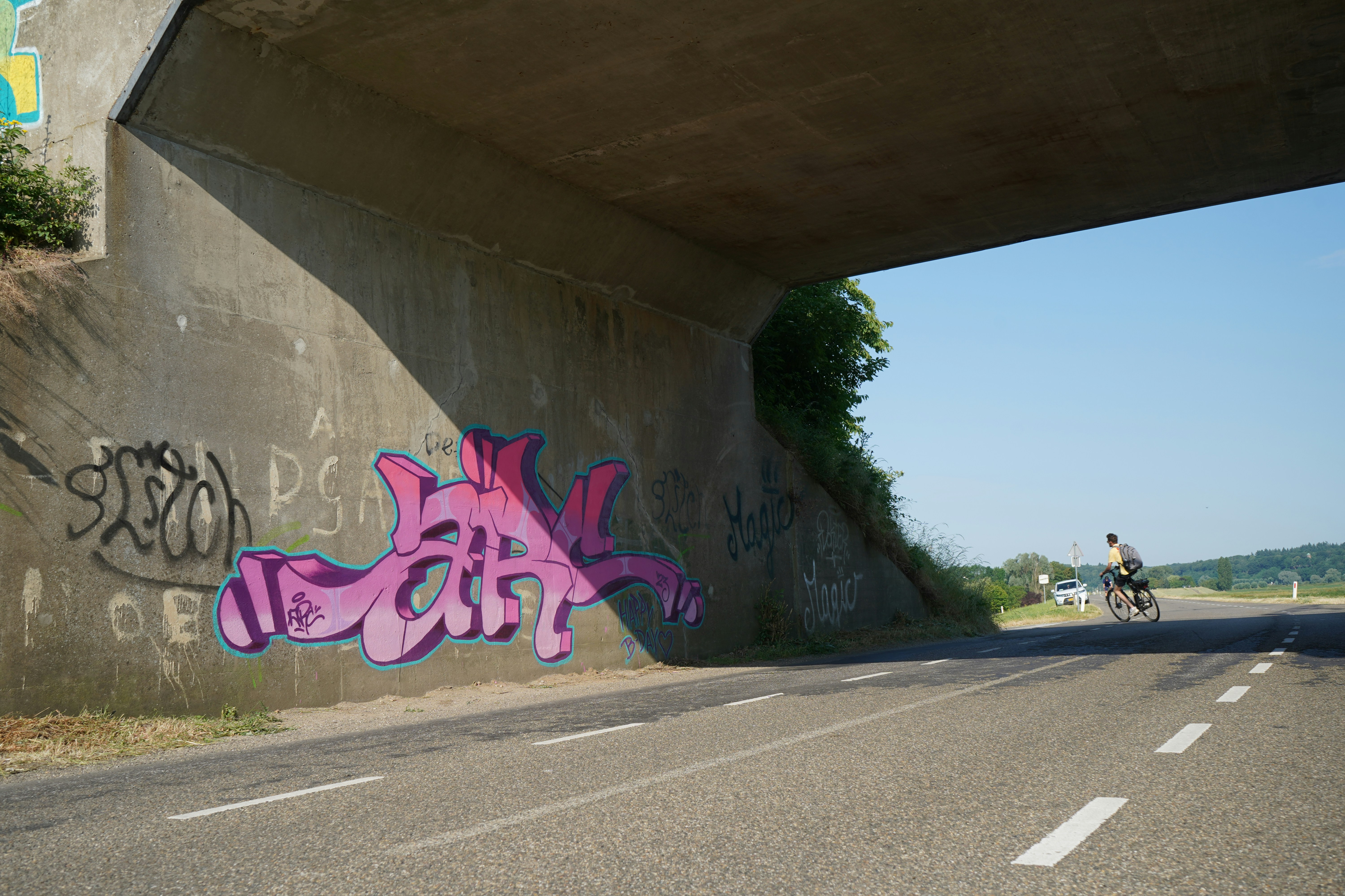 Graffiti under the highway arch: a quiet road trip scene