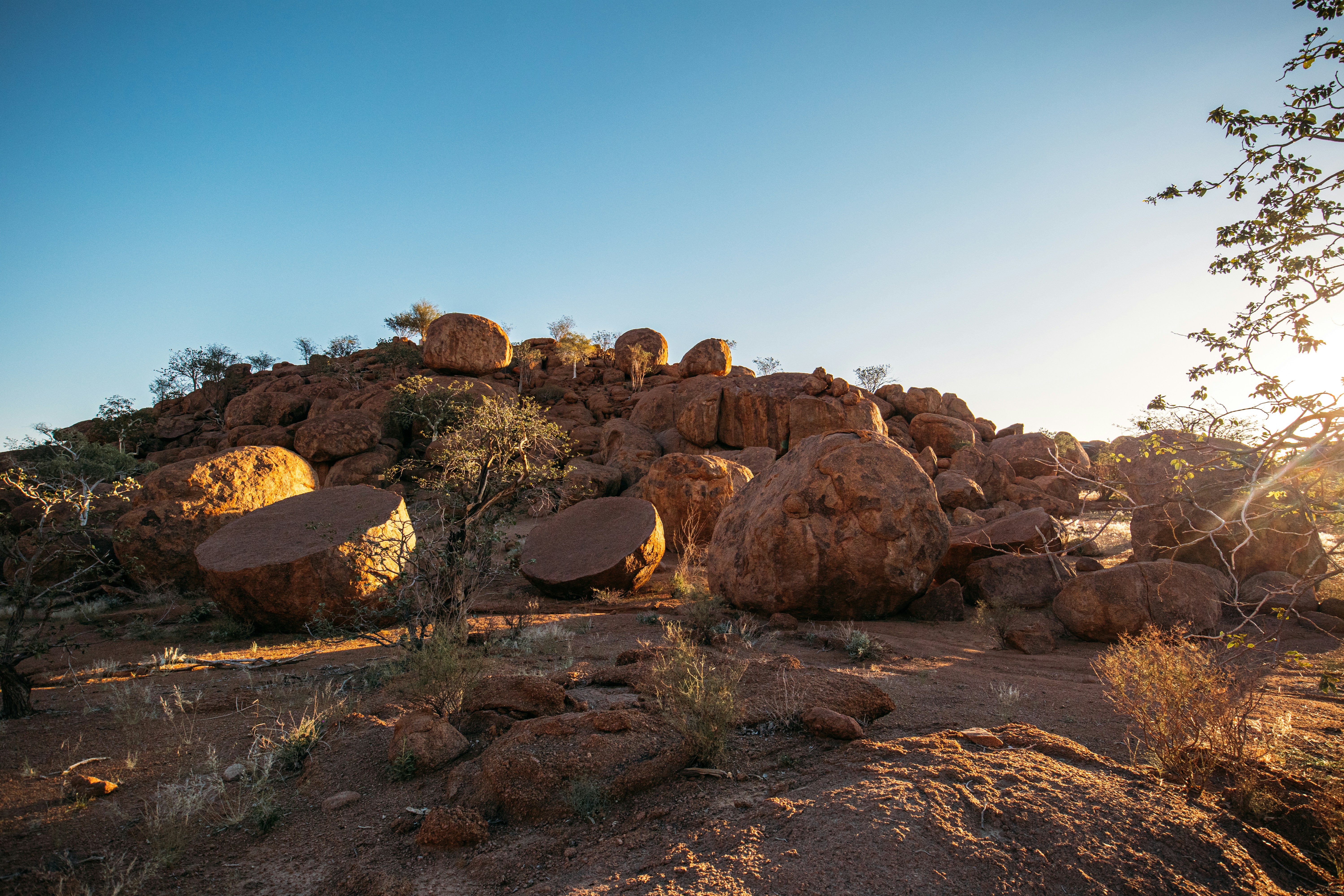 Rocky desert landscape with large, round, reddish-brown boulders.