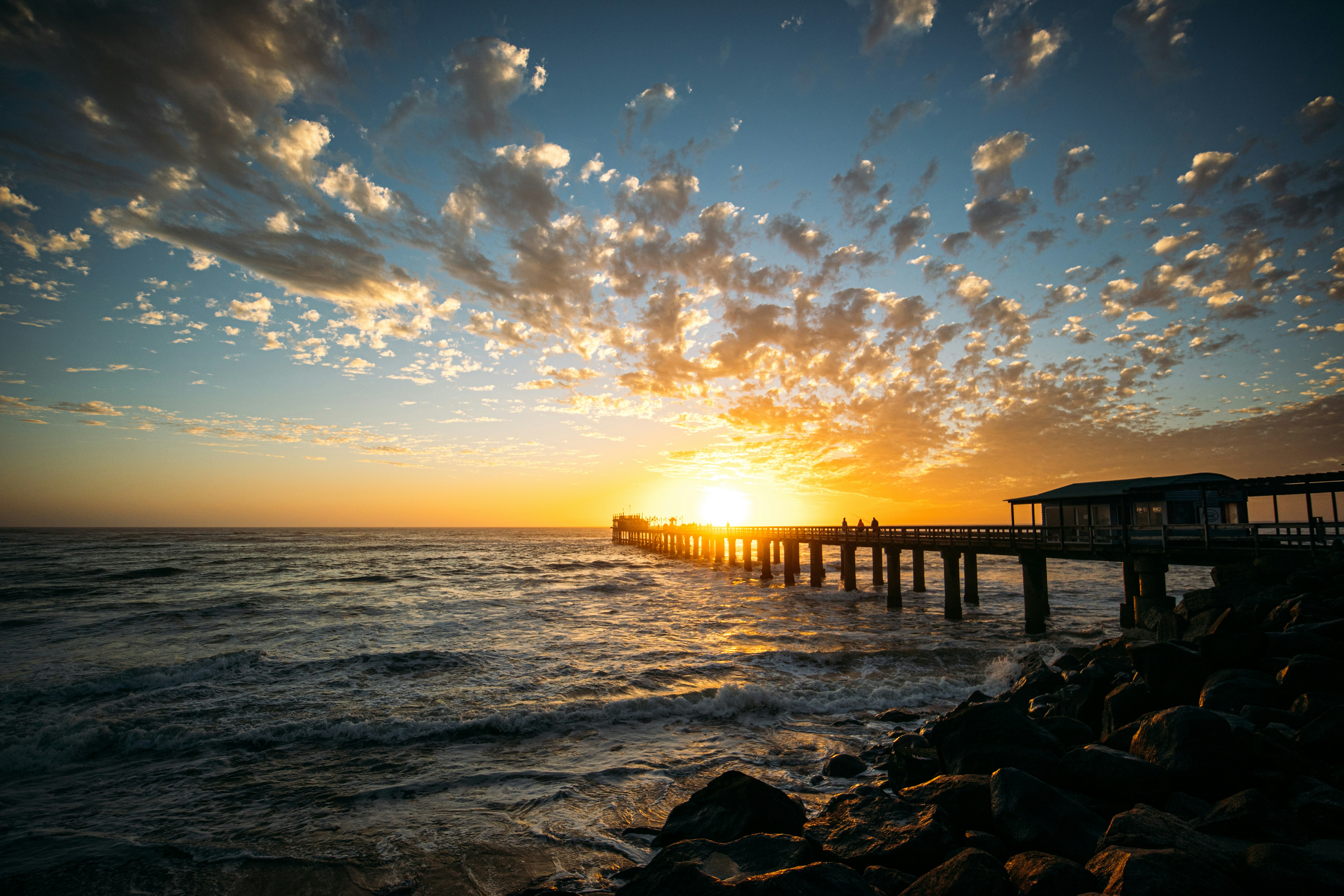 Sunlit Pier: Golden Hour Over Calm Seas