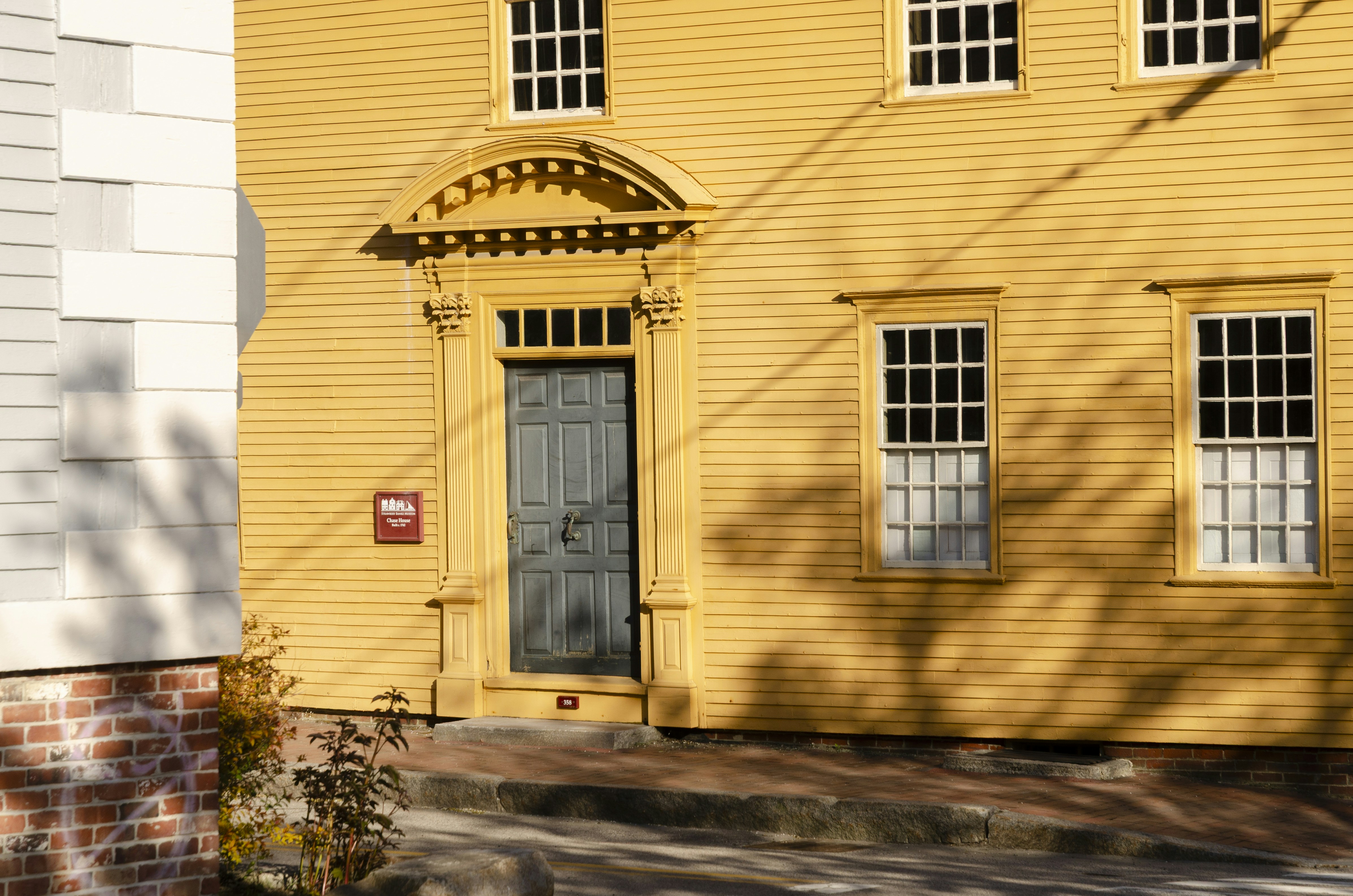 Sunlit Yellow Facade with Shadowed Archway