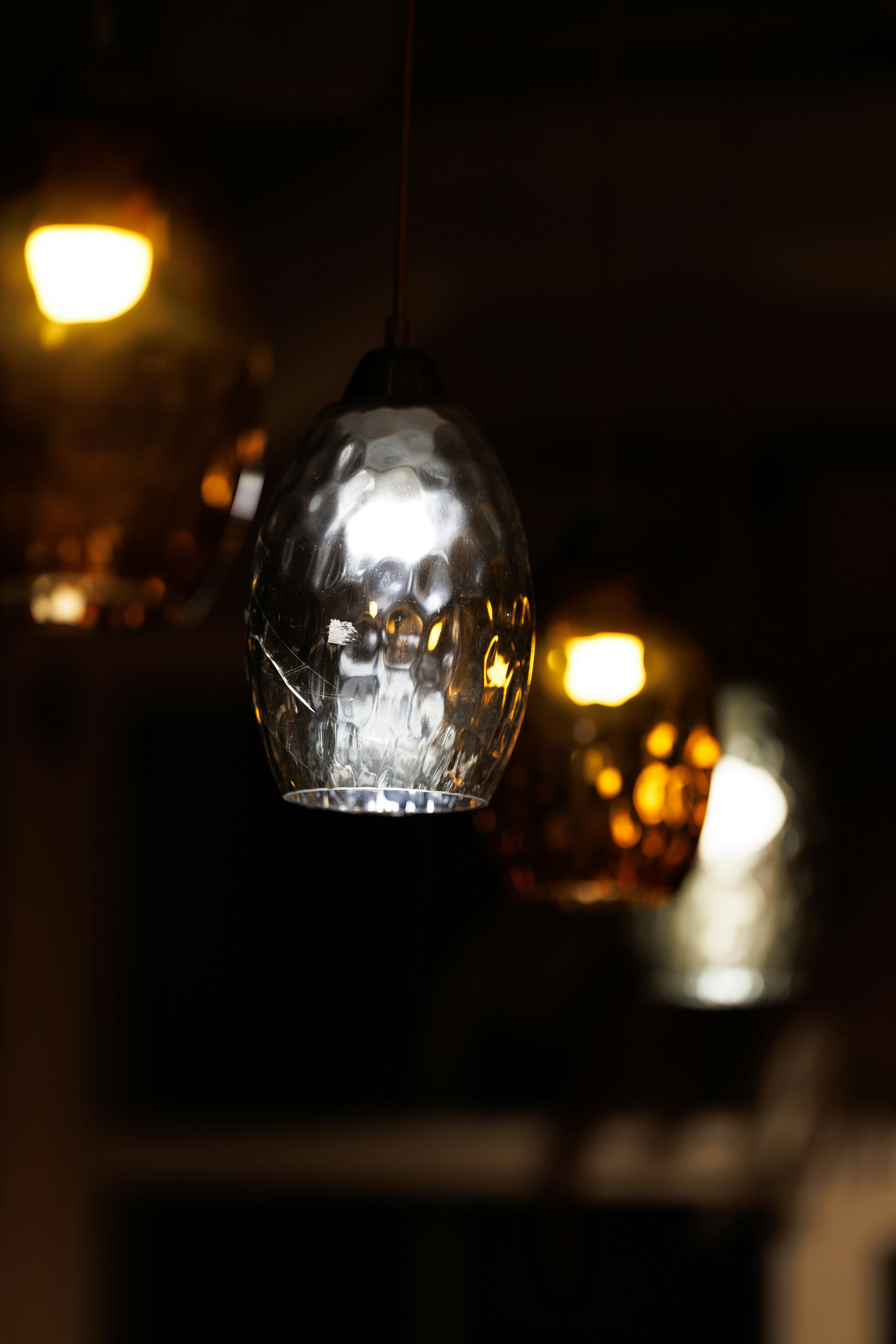 Hanging Glow: A Trio of Glass Lamps in Velvet Darkness