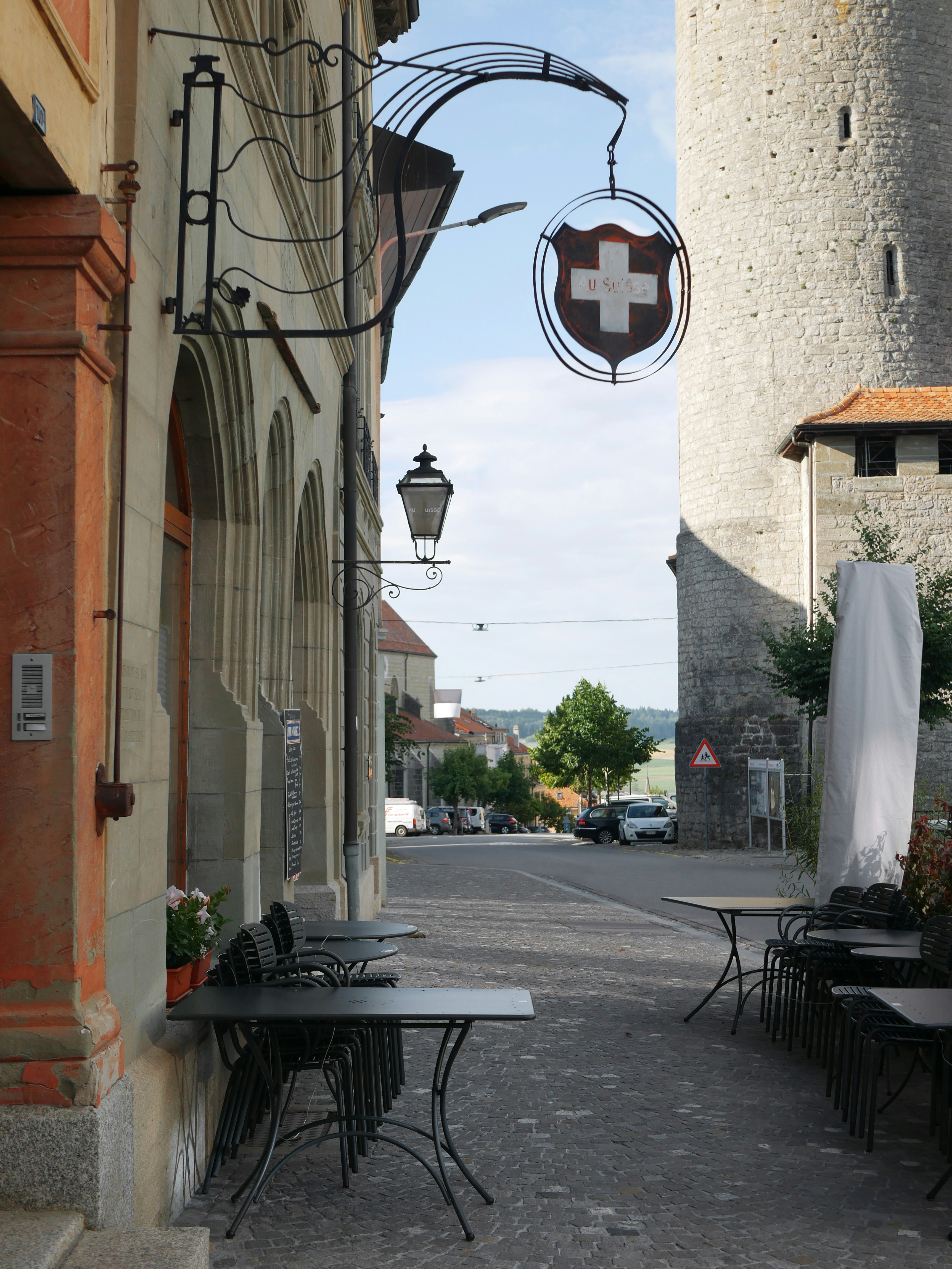 Cobbled Street Café Under a Medieval Arch