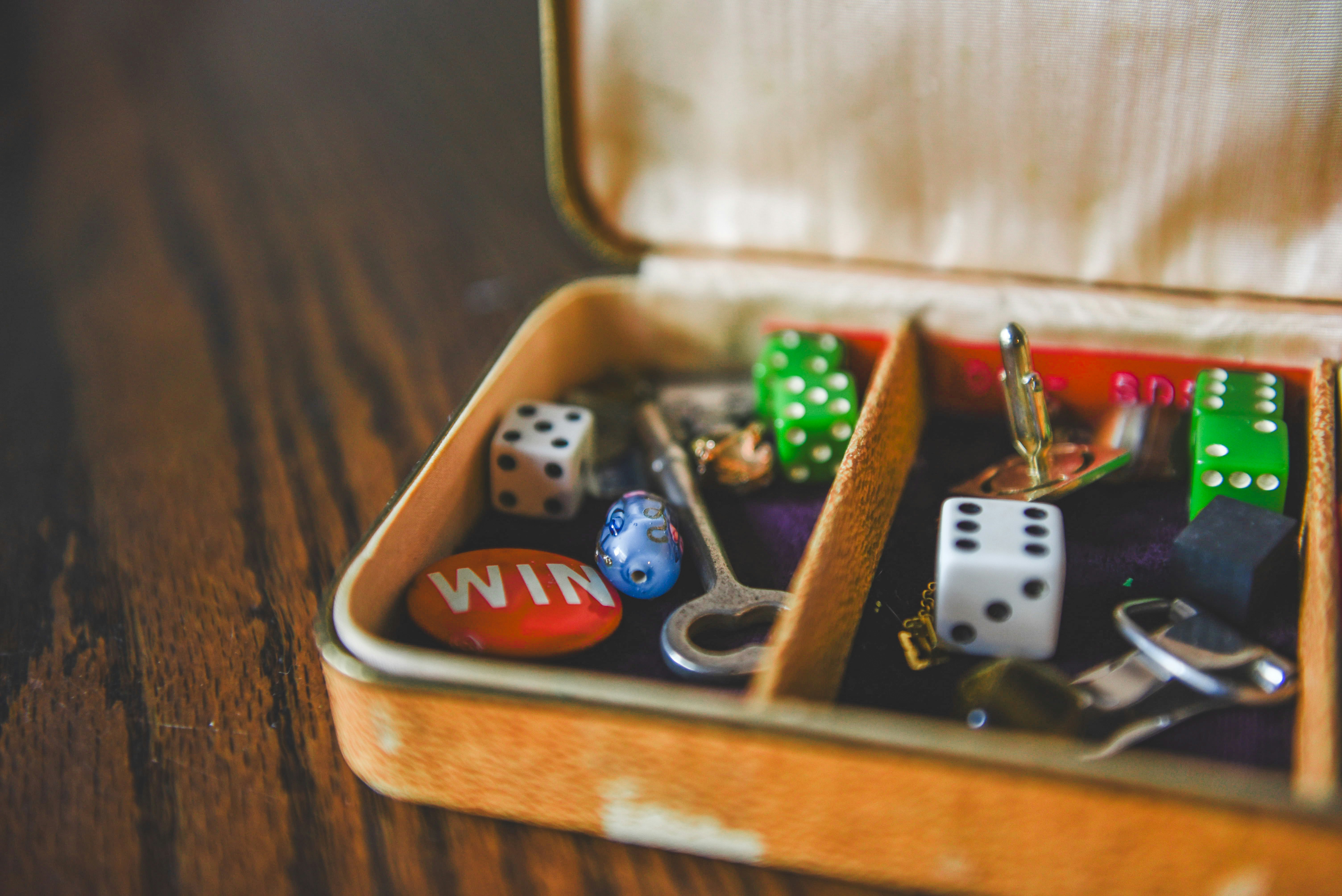 Tiny Wins: A pocketful of dice and a red ship token in a wooden case