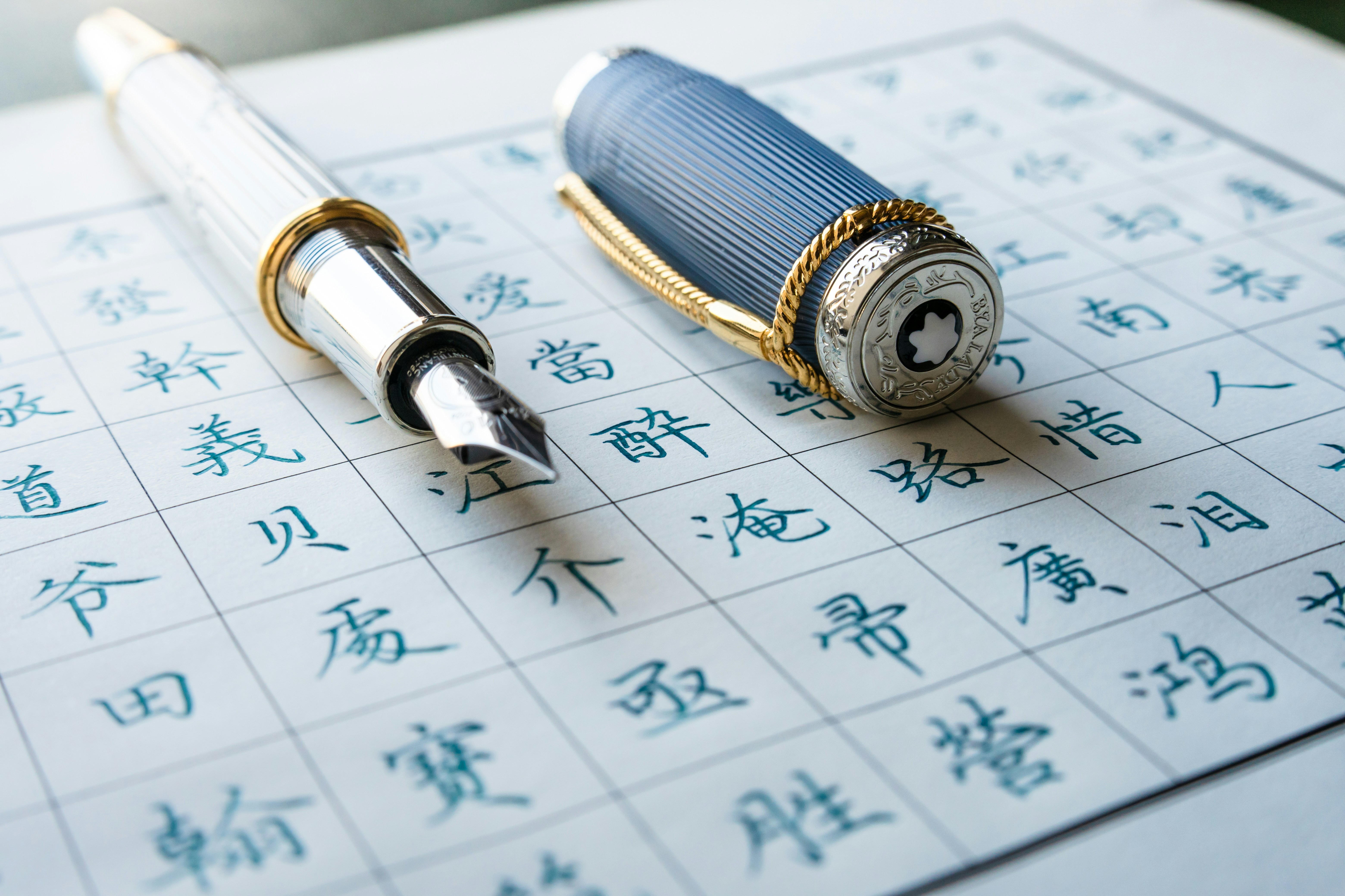 Ink and Script: A Close-Up of a Fountain Pen Resting on Flowing Chinese Characters