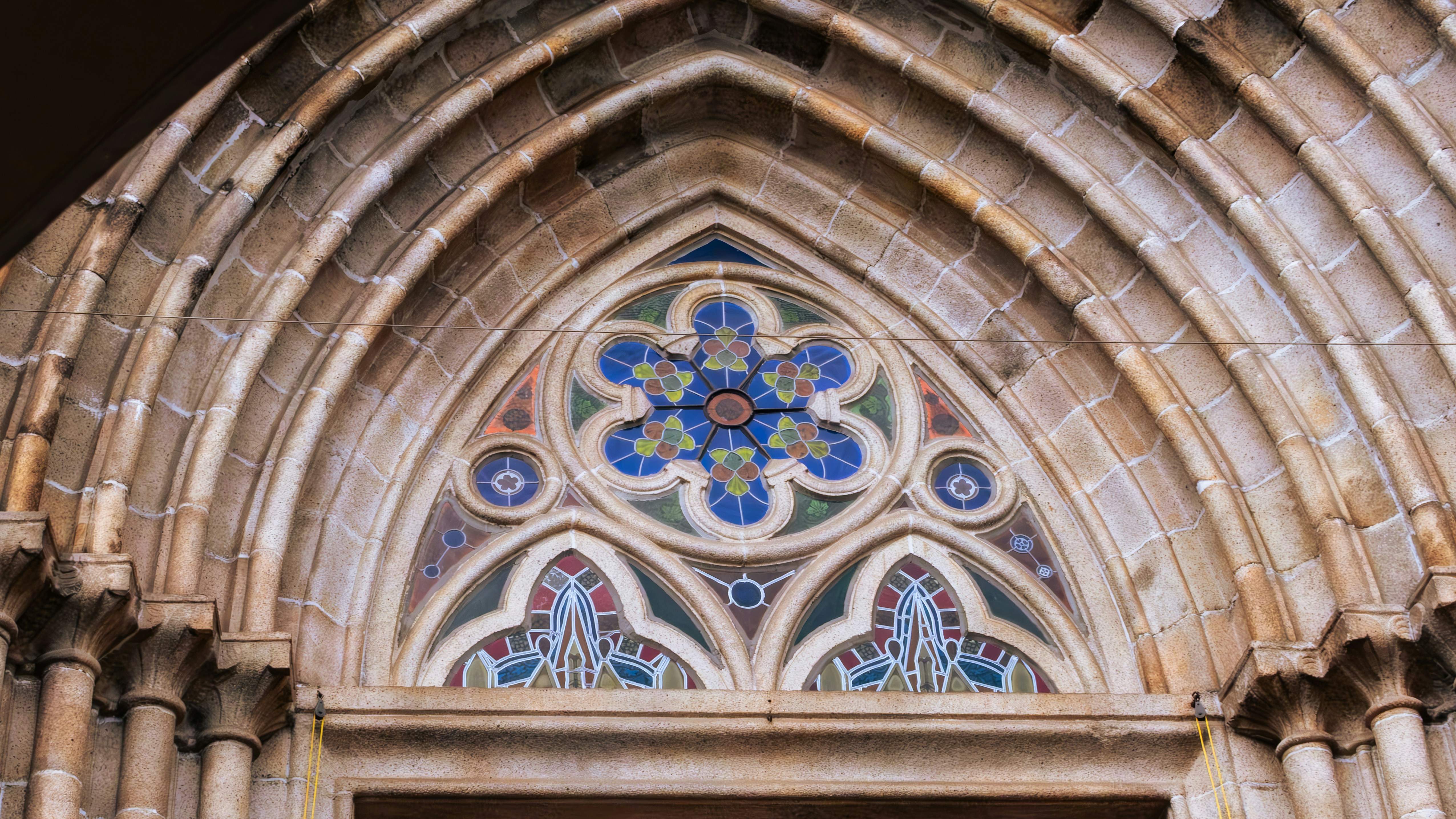 Stained Glass Archway: Centered Framed Bloom in Stone Cathedral