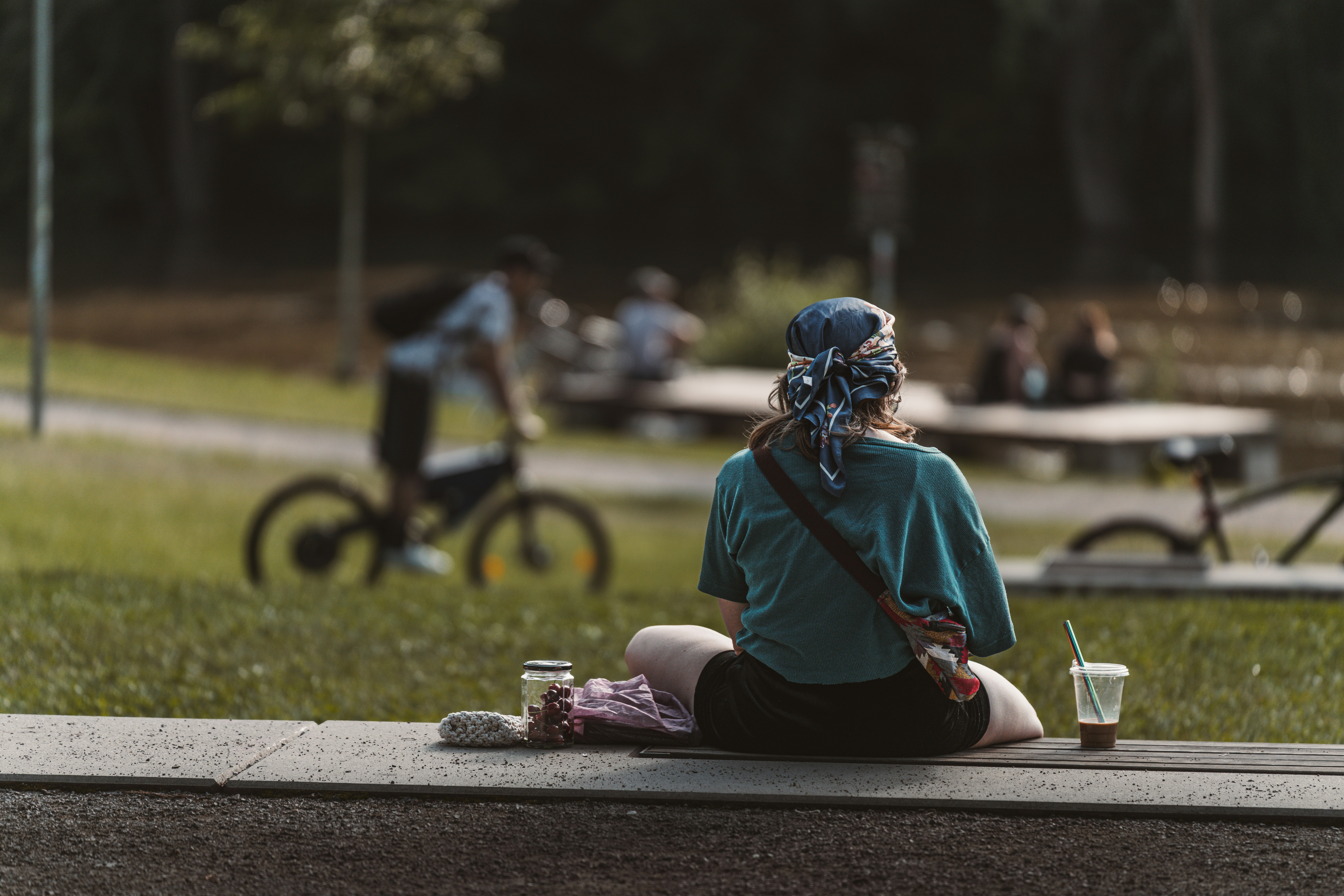 Quiet hillside respite: a lone cyclist and friends in the park