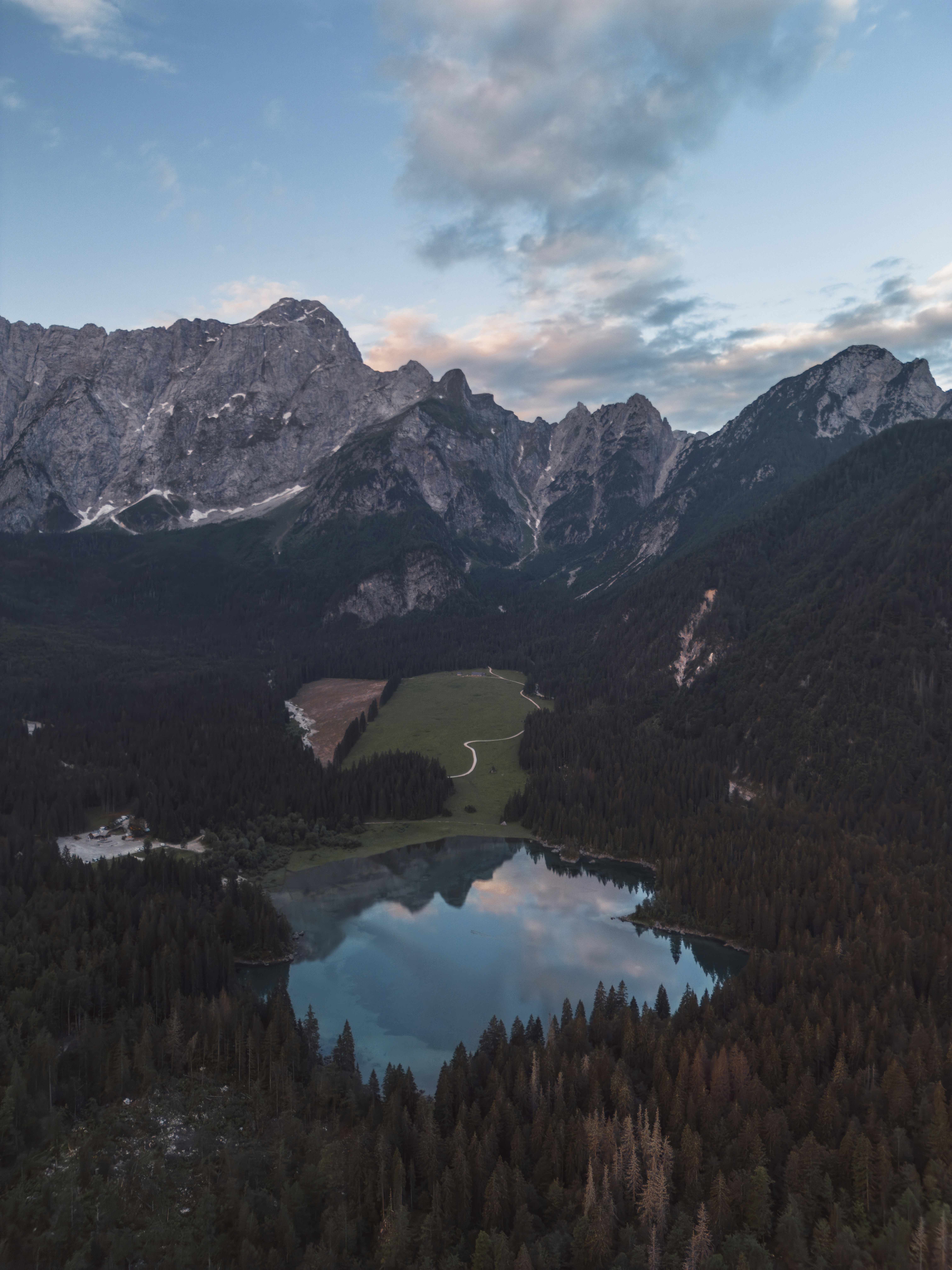Serene Alpine Mirror: A Lake Nestled Between Jagged Peaks