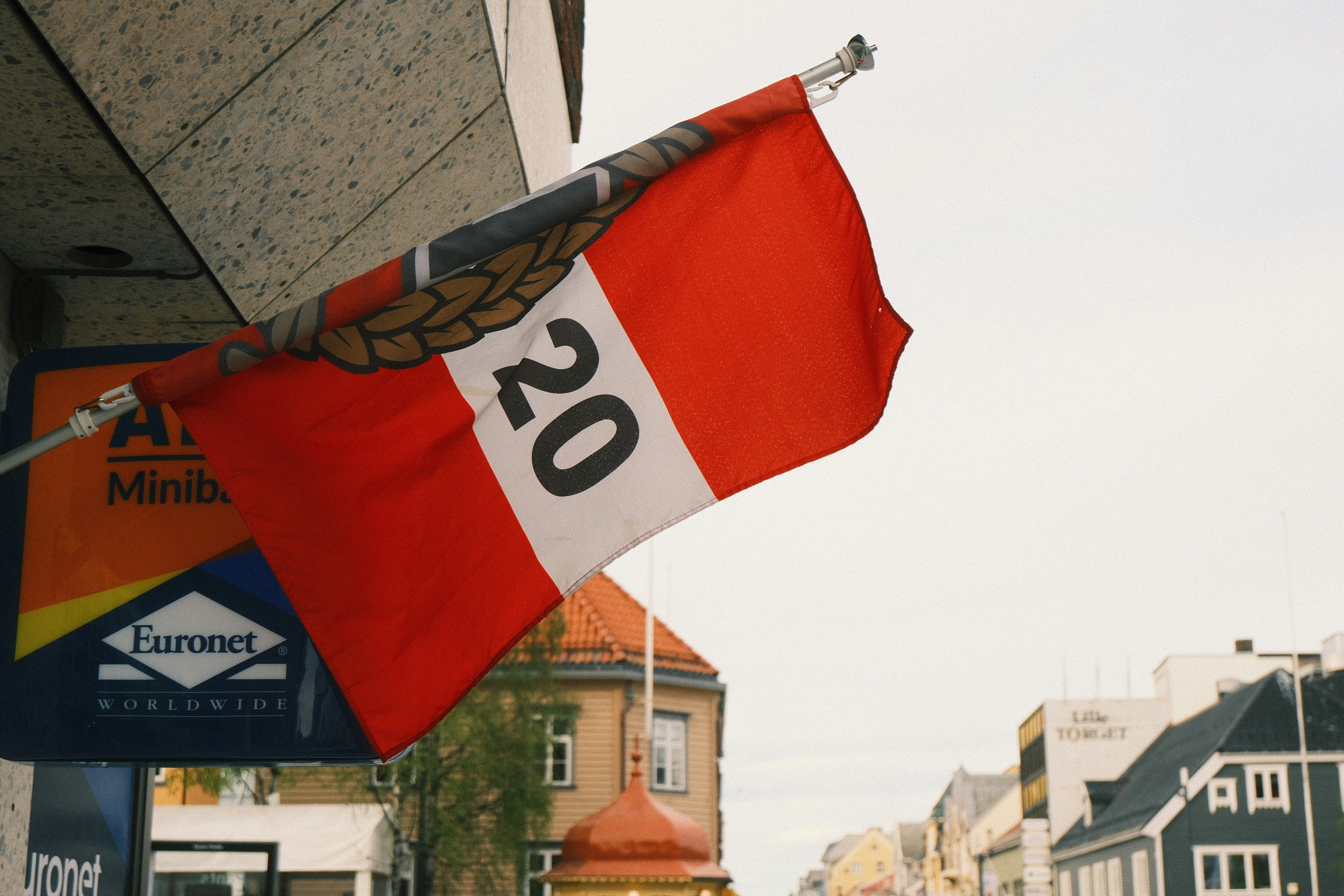 Red 20 Flag Over a Quiet European Street