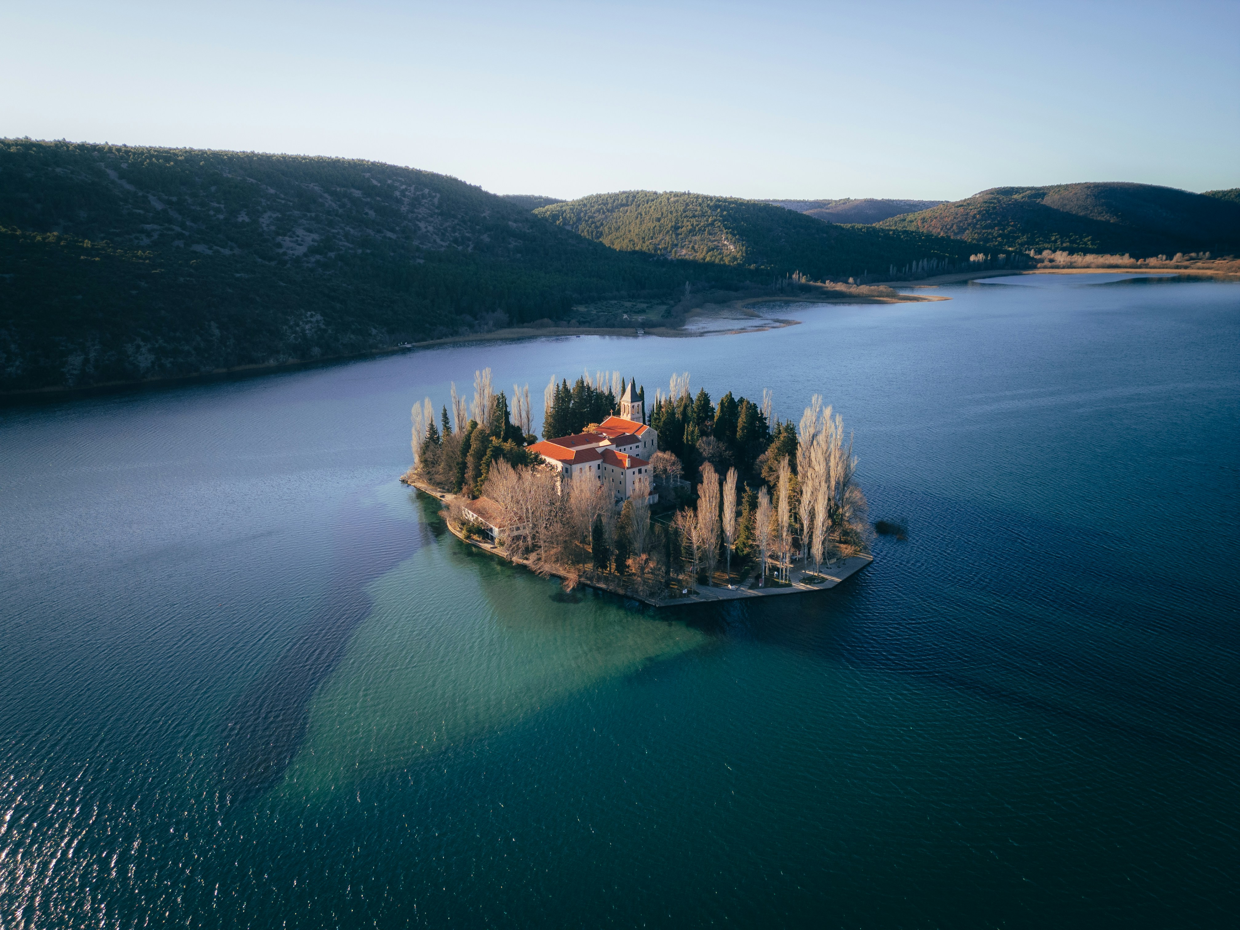 Island Monastery Crest: A Lone Structure Surrounded by Emerald Waters